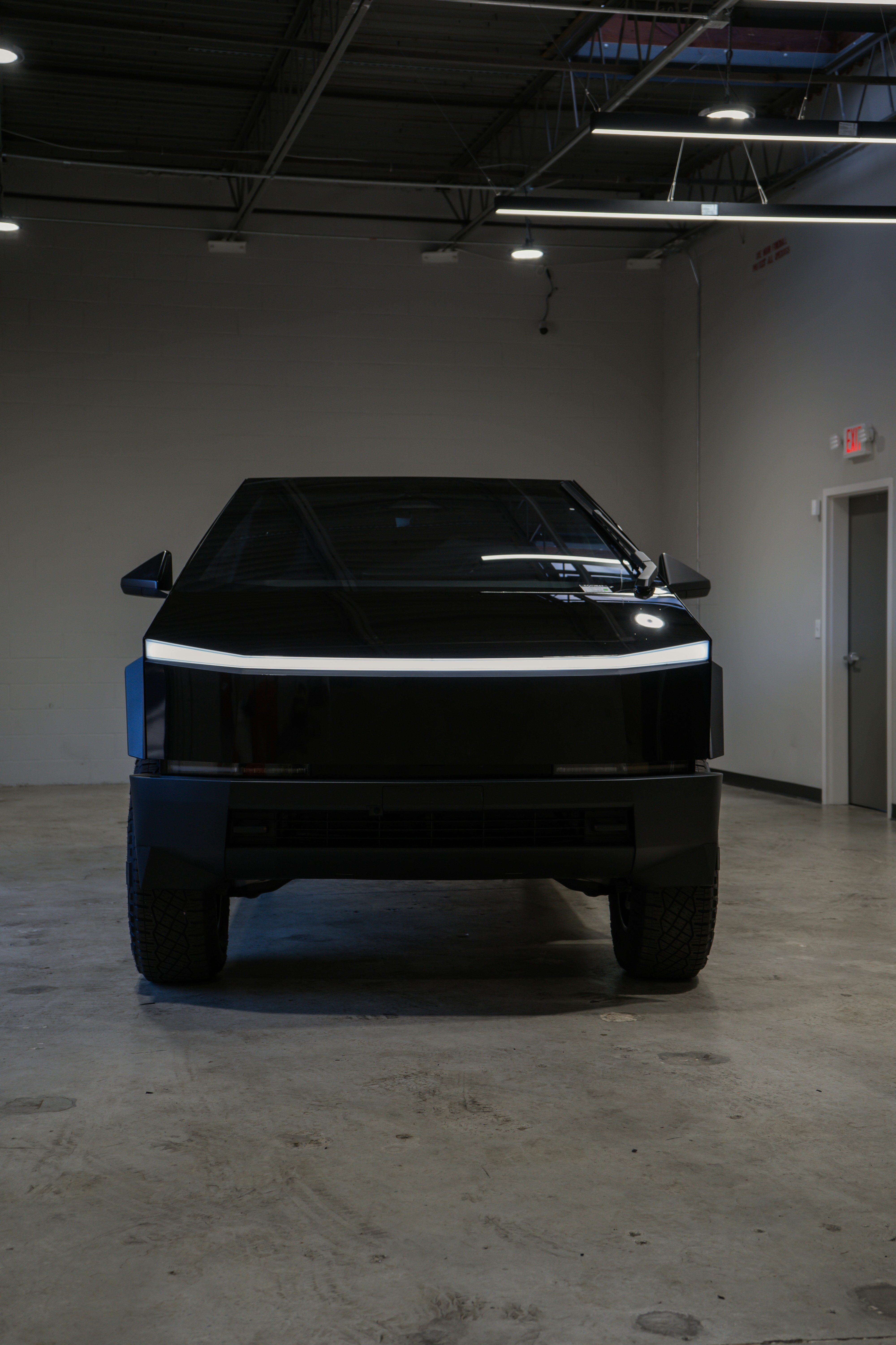 Midnight Monolith: A Bold Black Pickup Standing Tall in an Industrial Hall