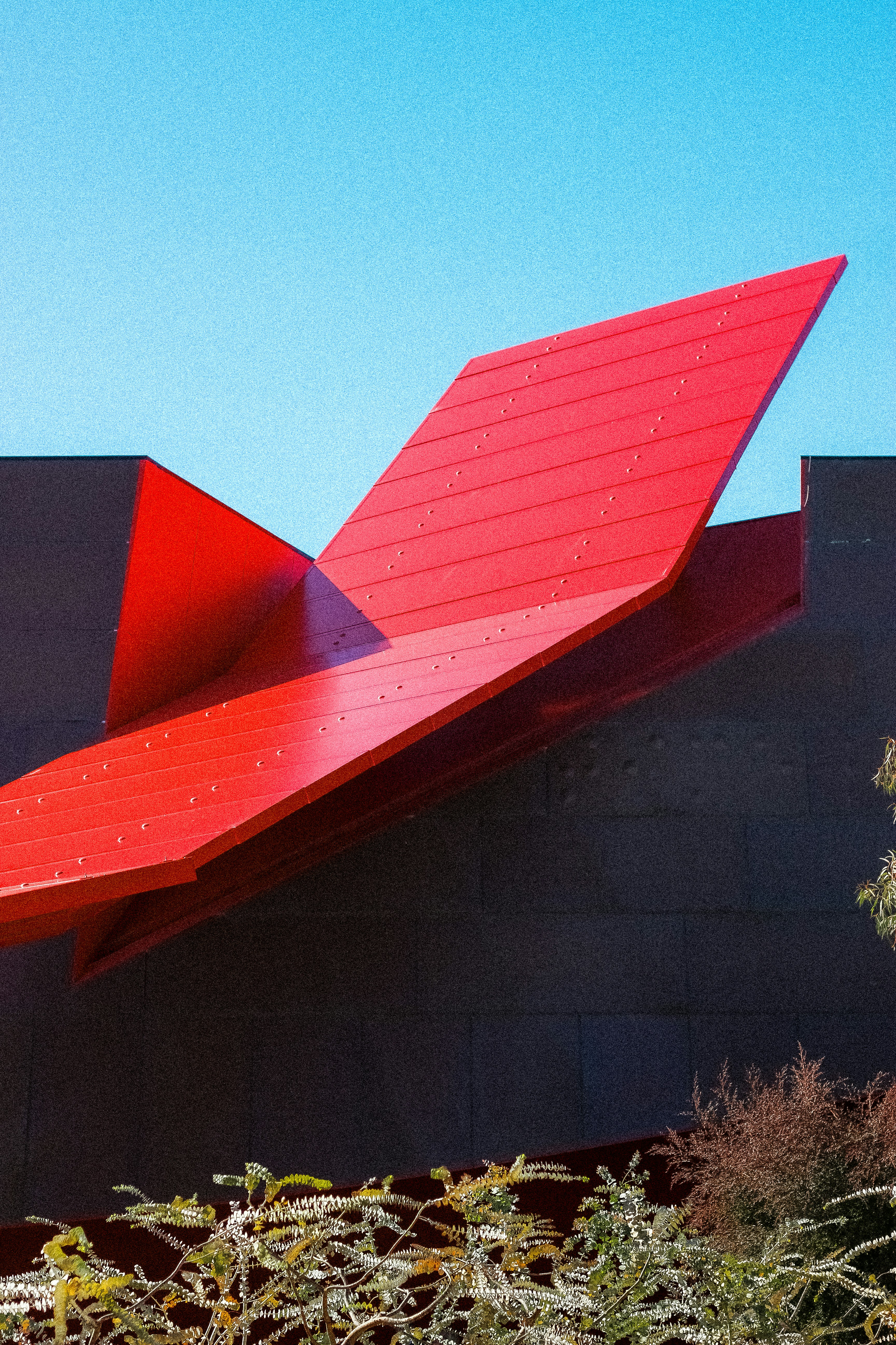 Red Architectural Blade Cutting the Blue Sky