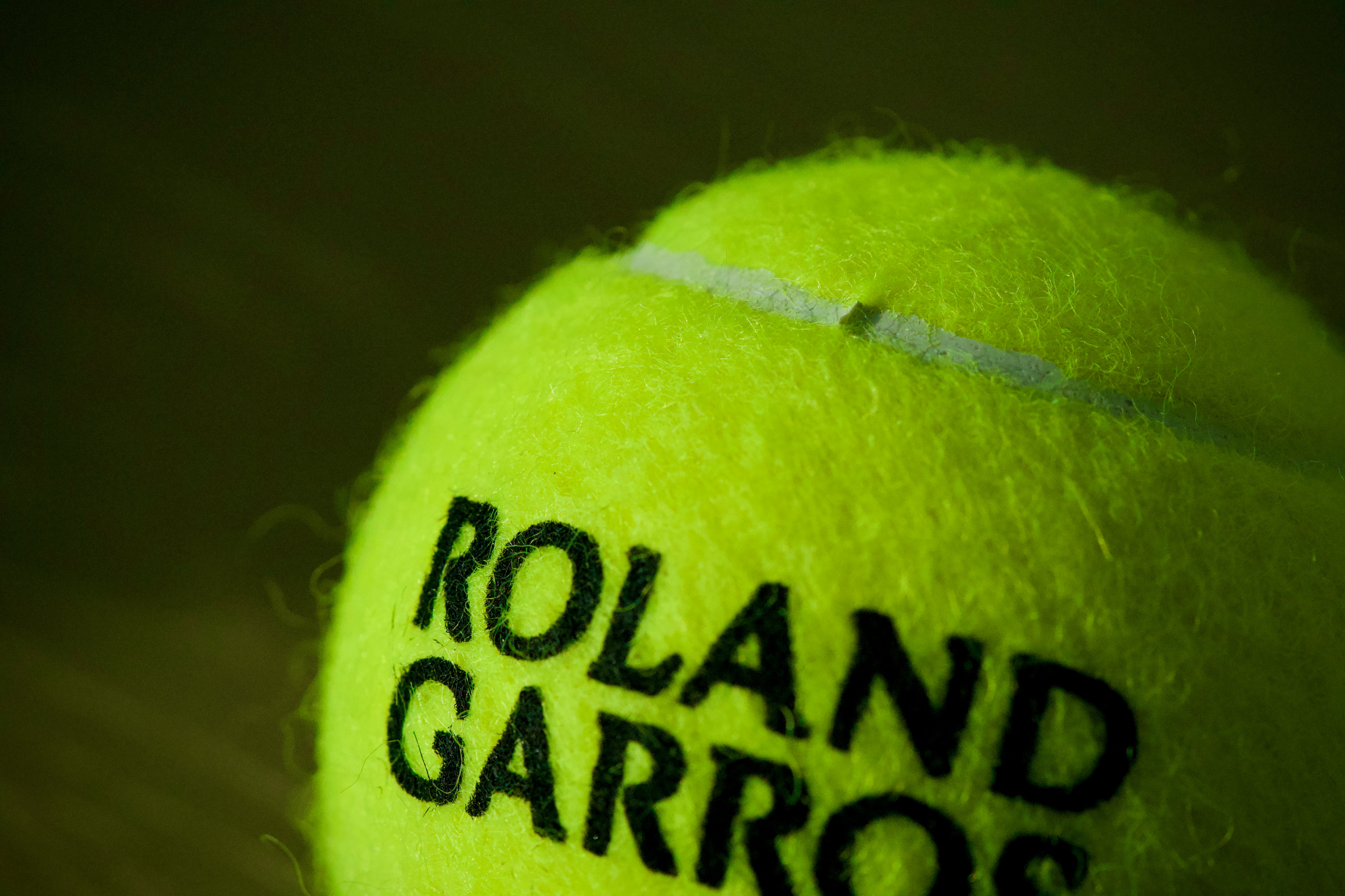 Neon-yellow tennis ball whispers Rolando Garros to the lens