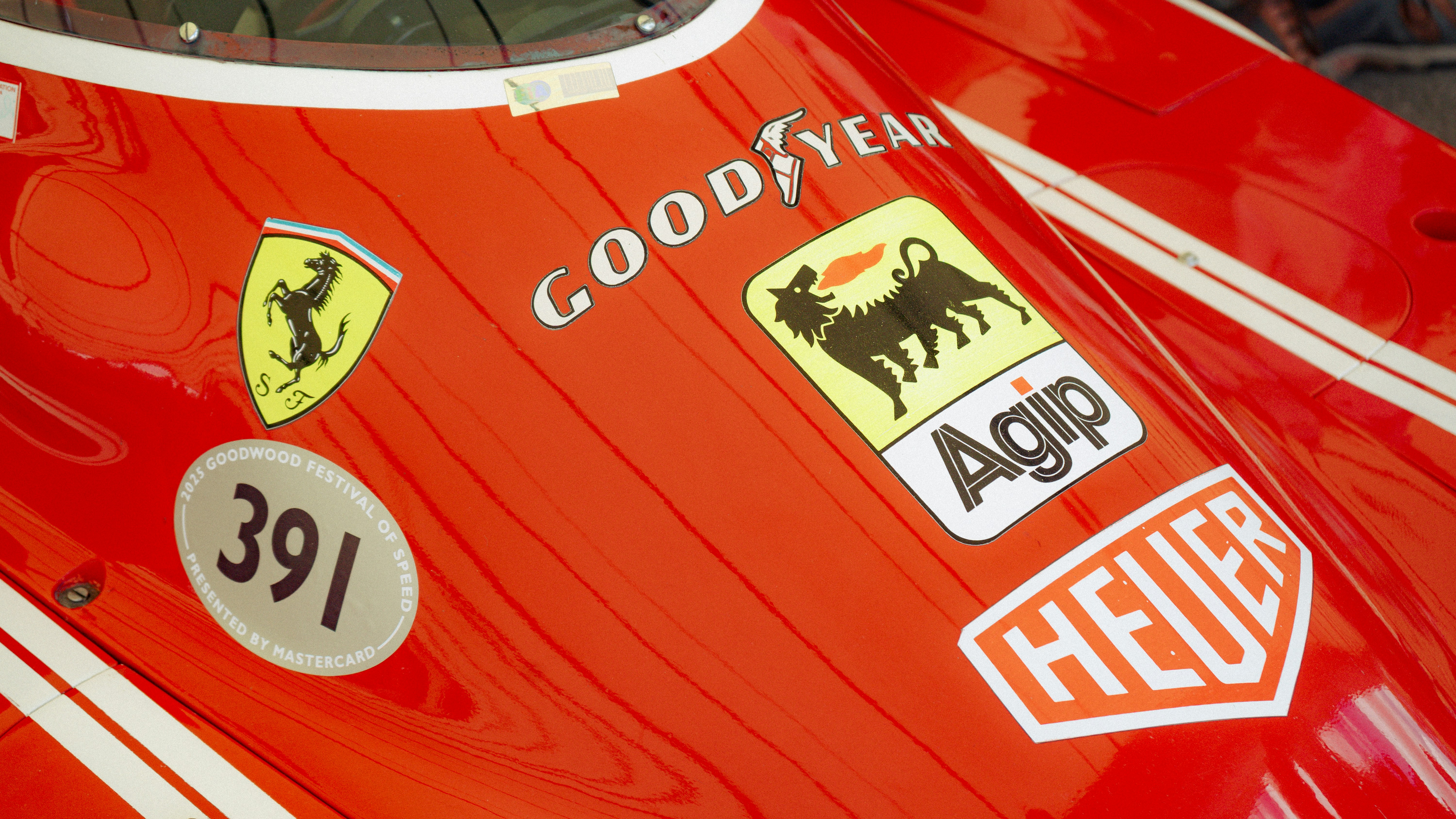 Racing Badge Close-Up: Red Shells and Logos on a Ferrari Engine Cover