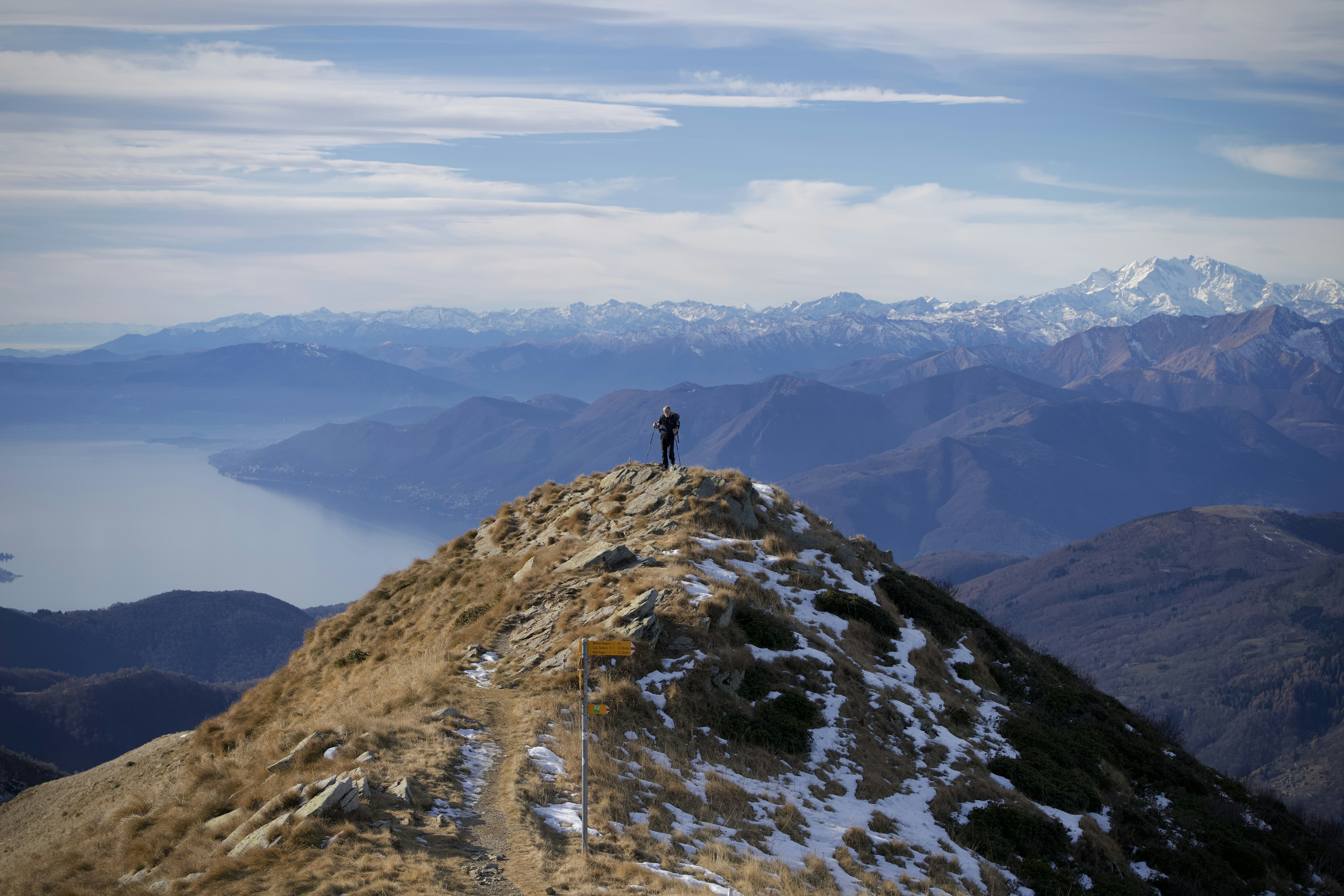  Summit Stature: lone hiker at the ridge under sweeping alpine skies