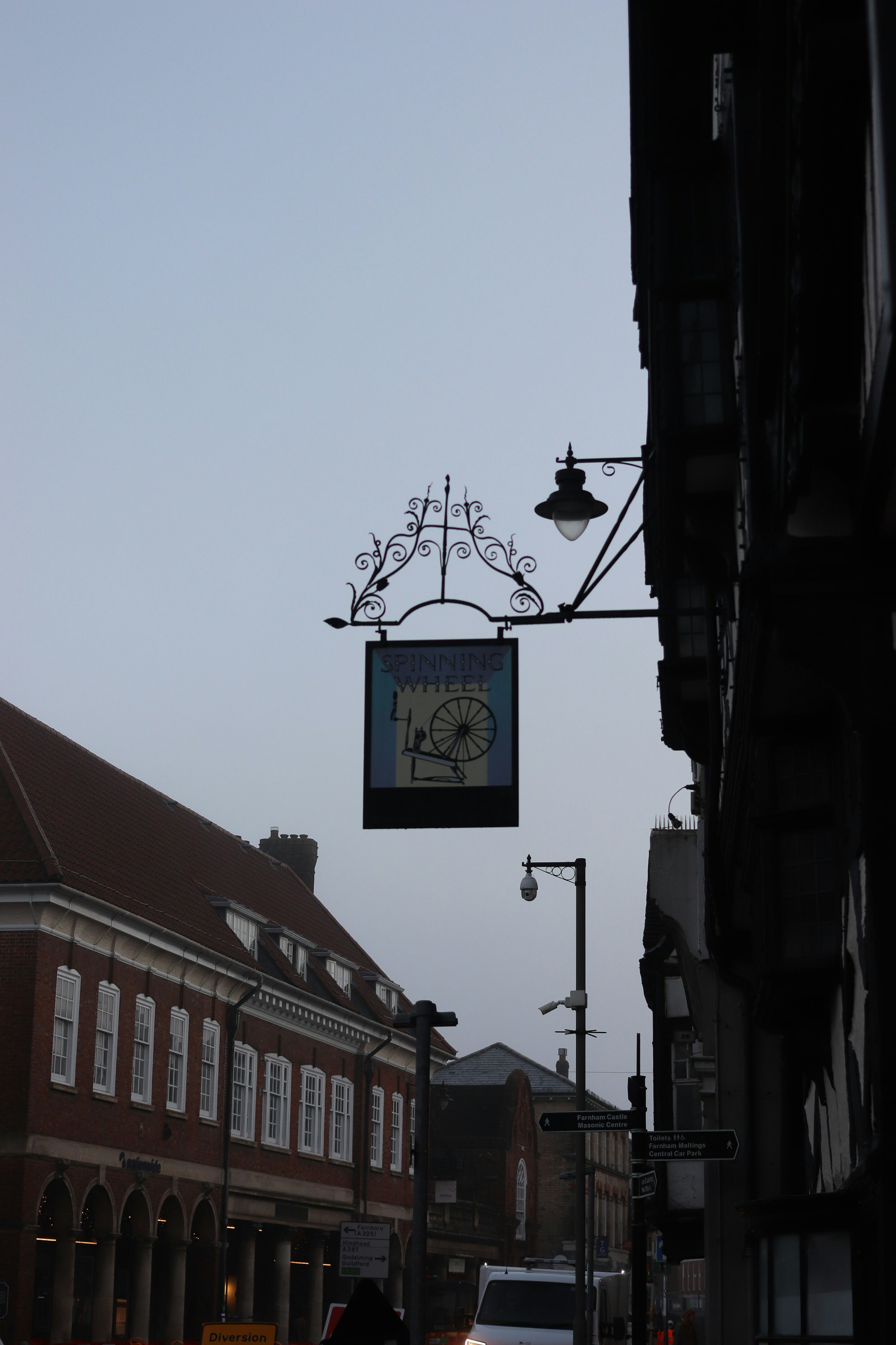 Signboard of a Wheel: Historic Street Scene Under Evening Light