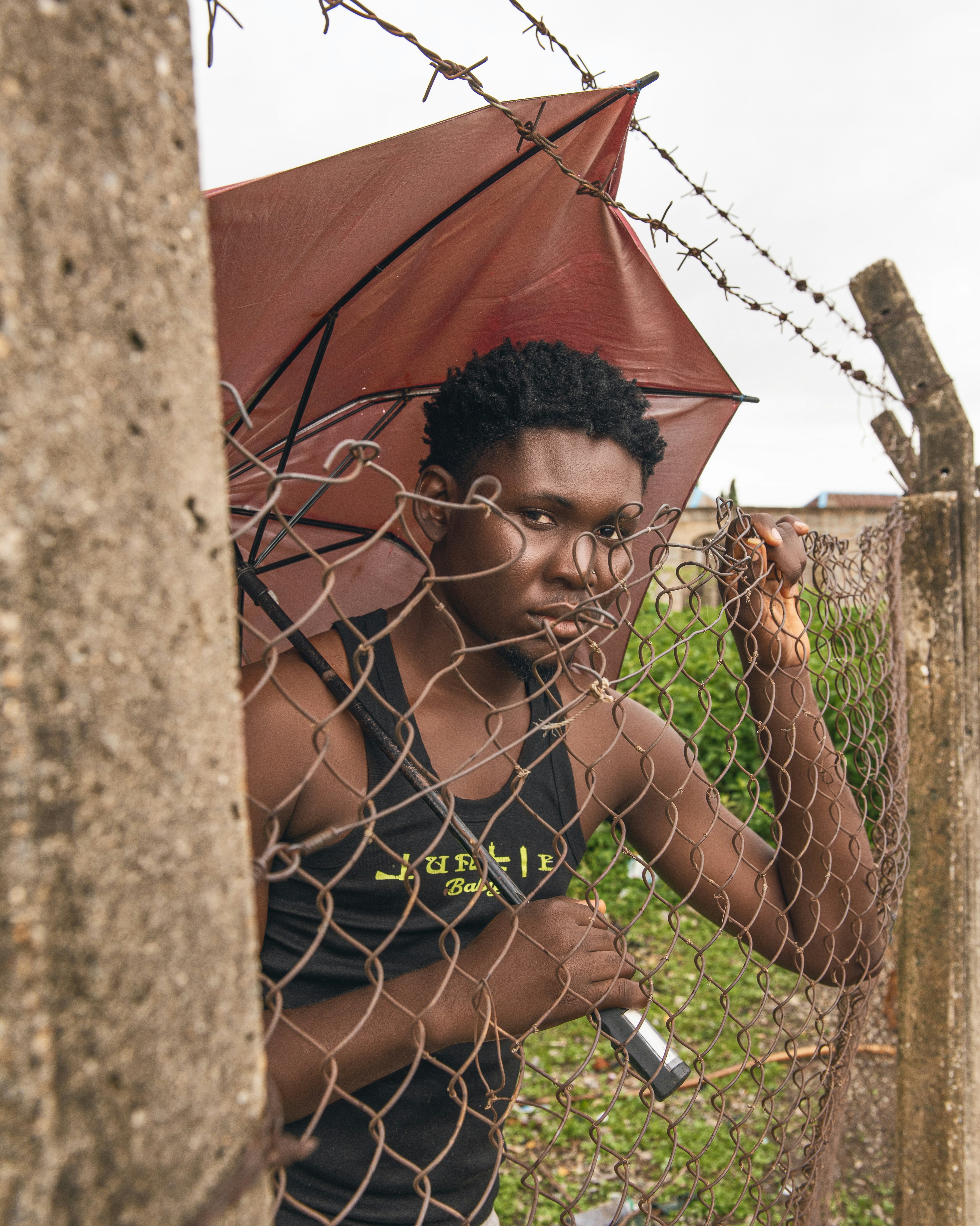 Barbed Danger, Soft Light: Portrait Behind a Fence