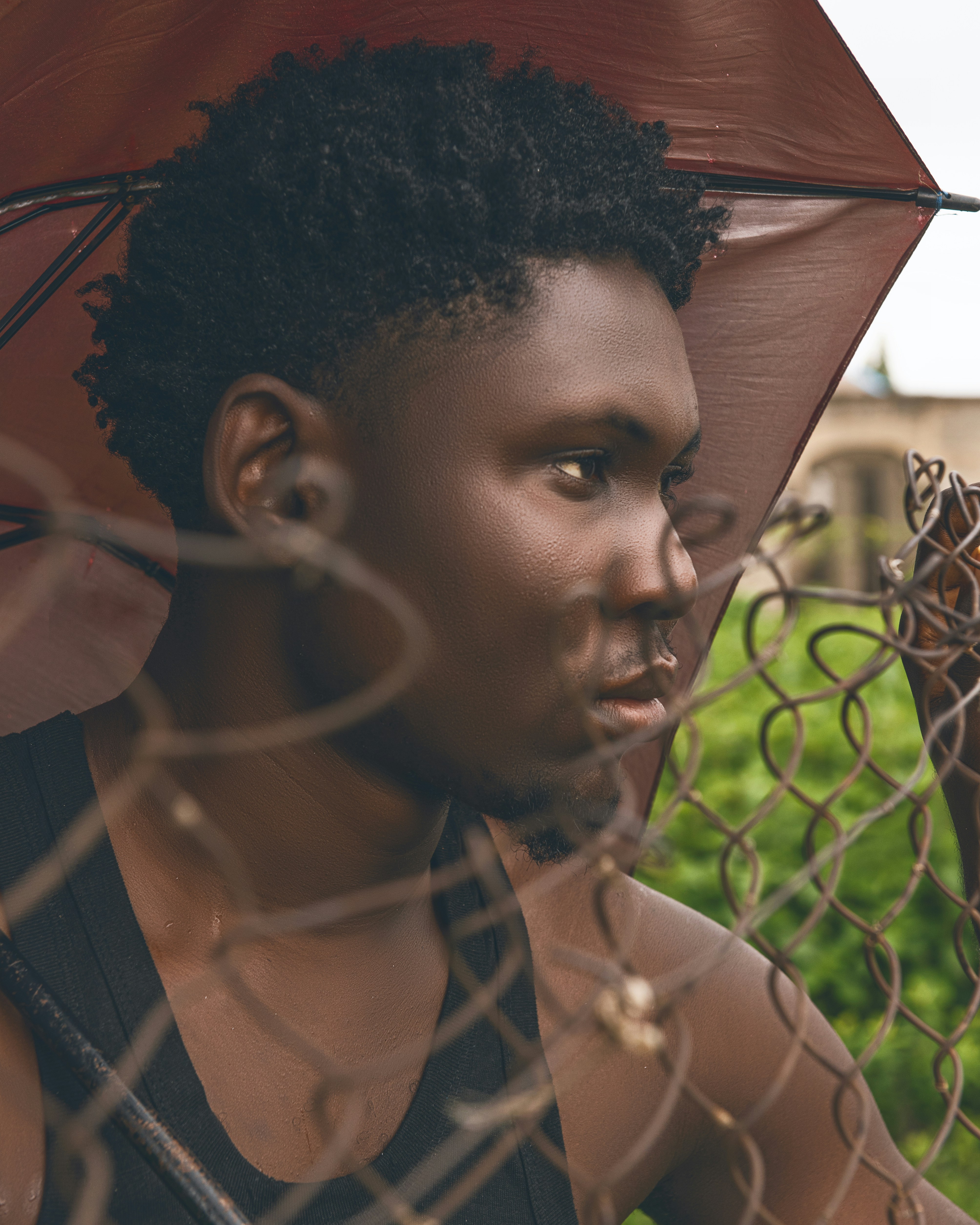 Under the Copper Umbrella: Portrait Behind a Fence