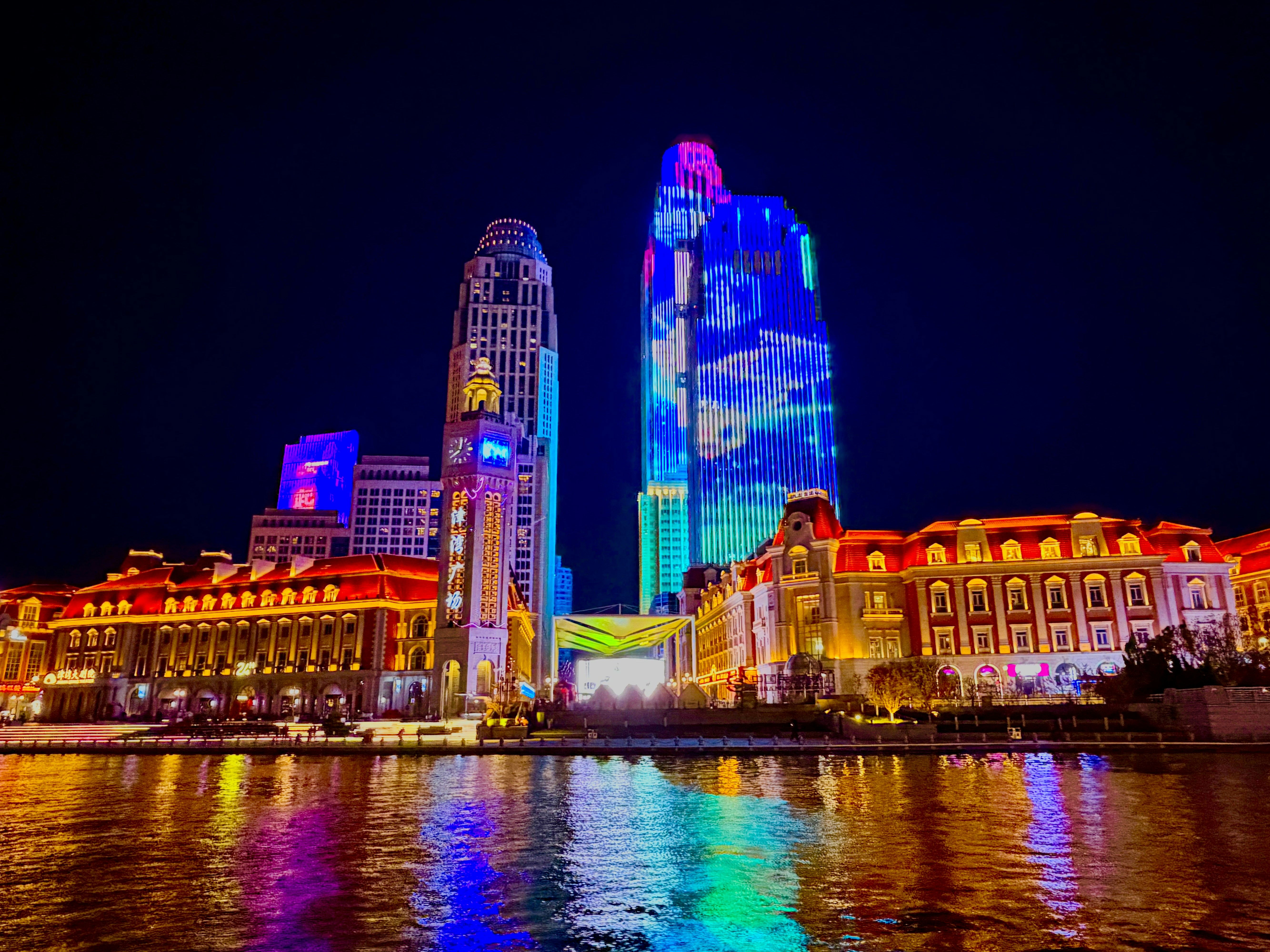 Neon Facade by the River: Night Orchard of Towers and Arcades