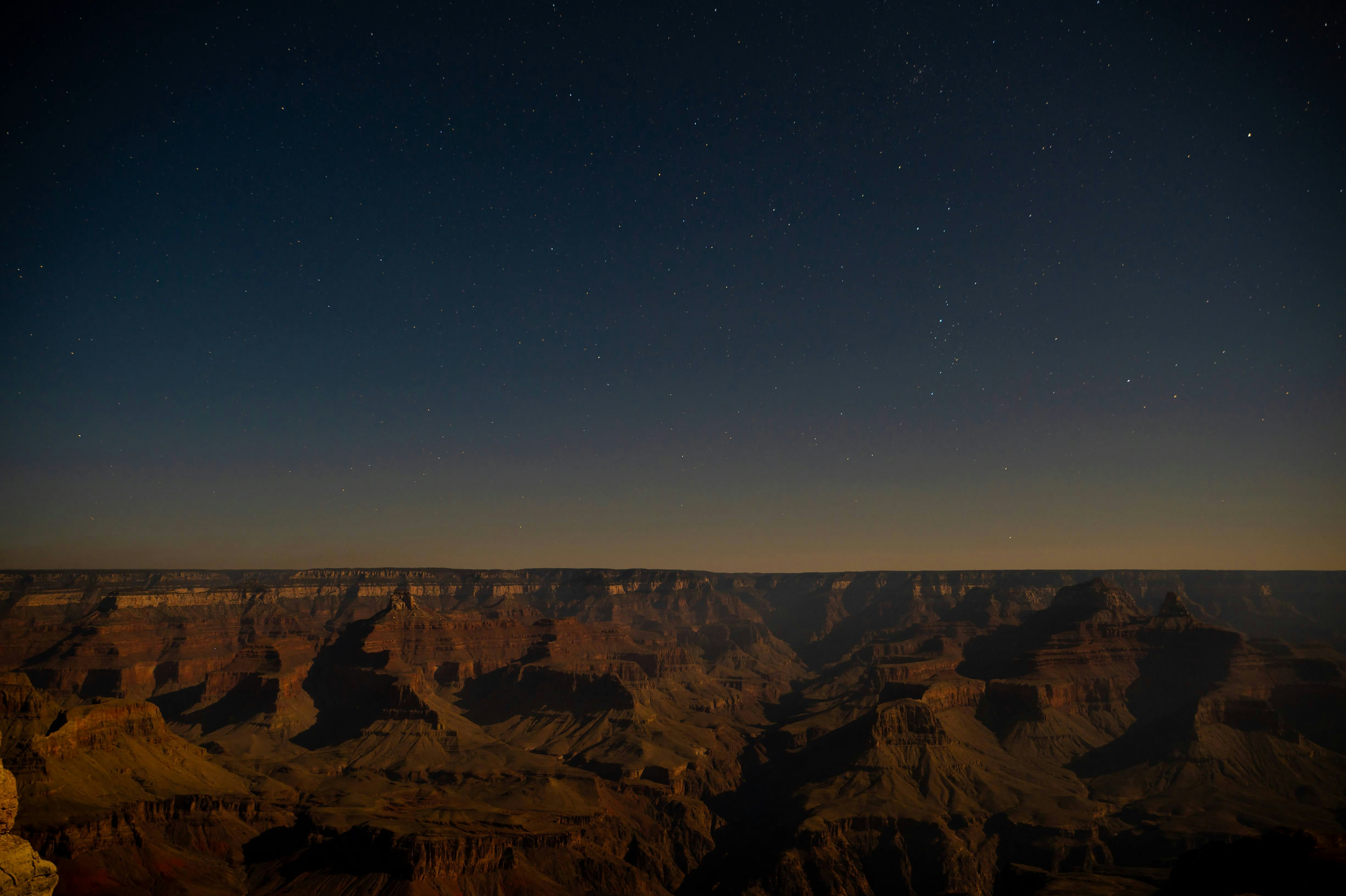  twilight over the canyon: starlit horizon above layered cliffs