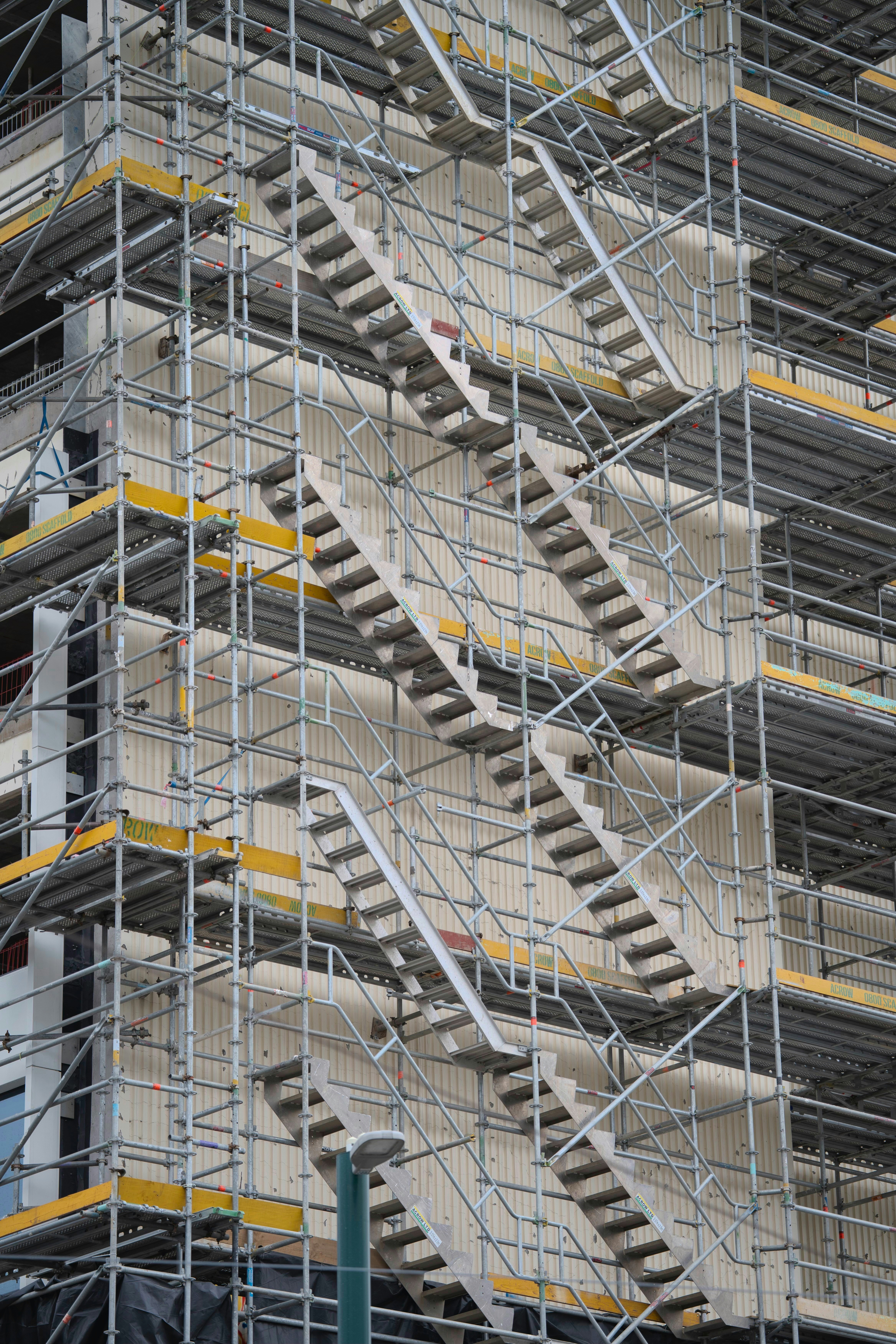 Building under construction with scaffolding and stairs photo – Free ...