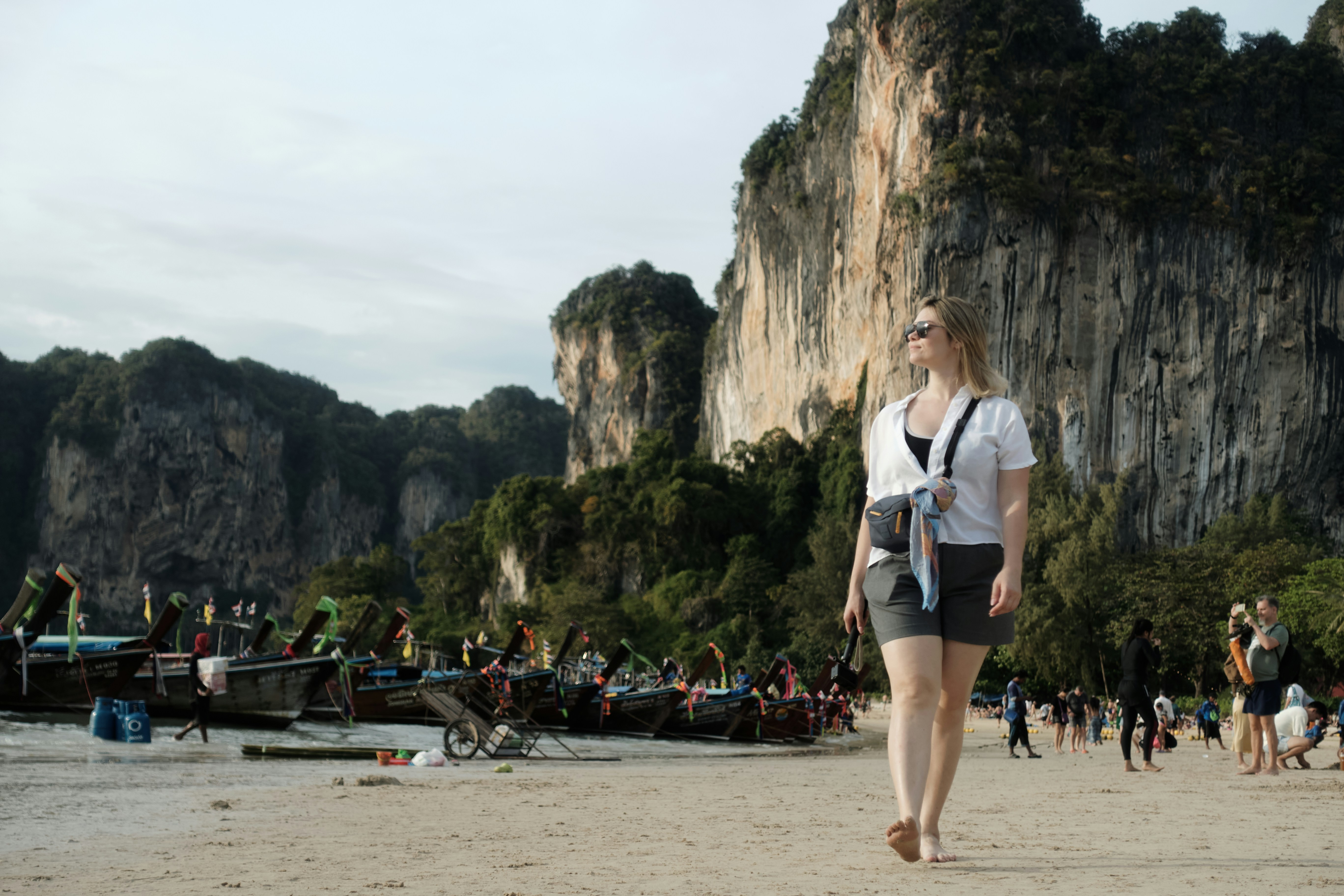 Lone Traveler Beneath Karst Cliffs at Backlit Beach
