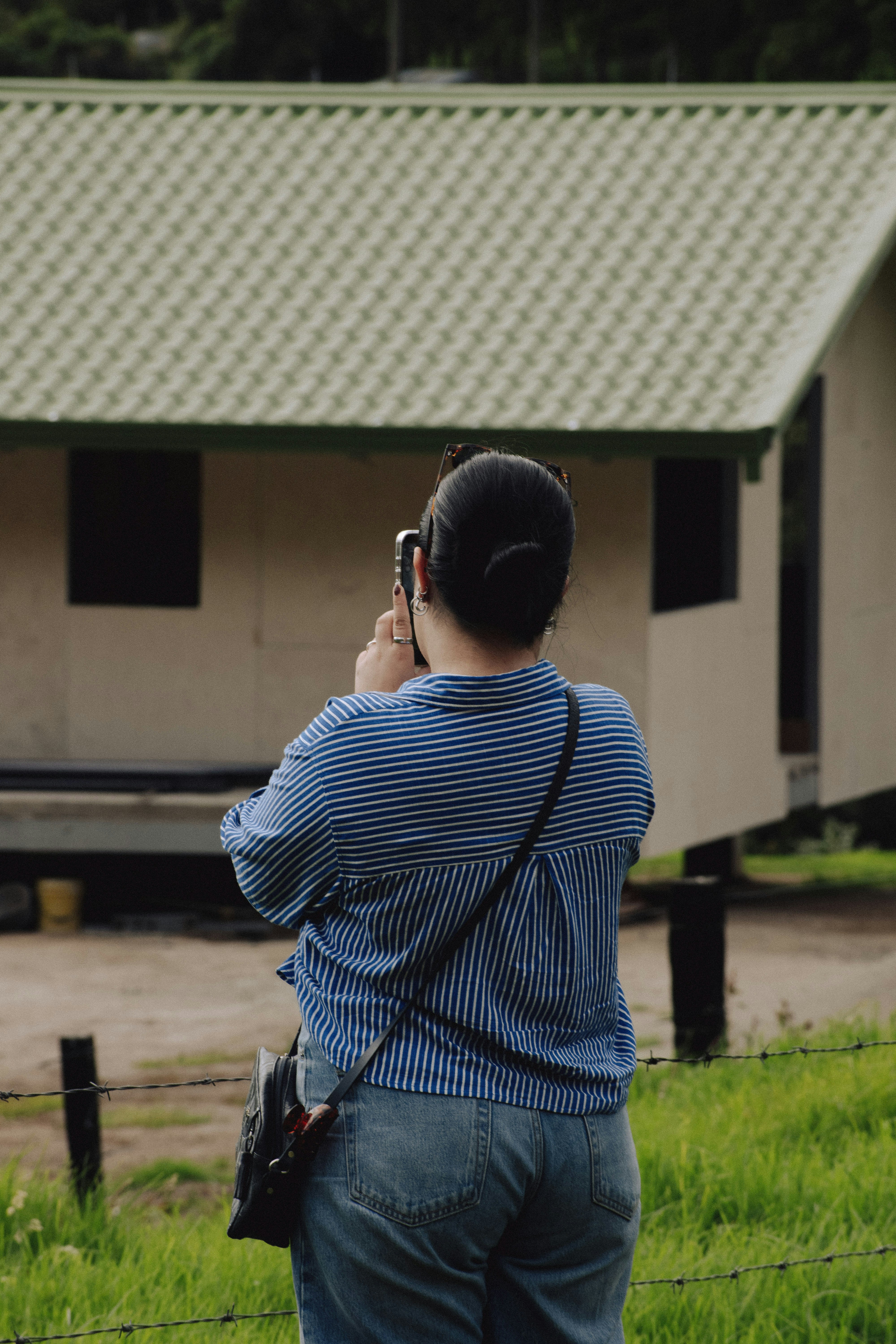 Backlit Moment: A Woman Photographing a Quiet Cabin