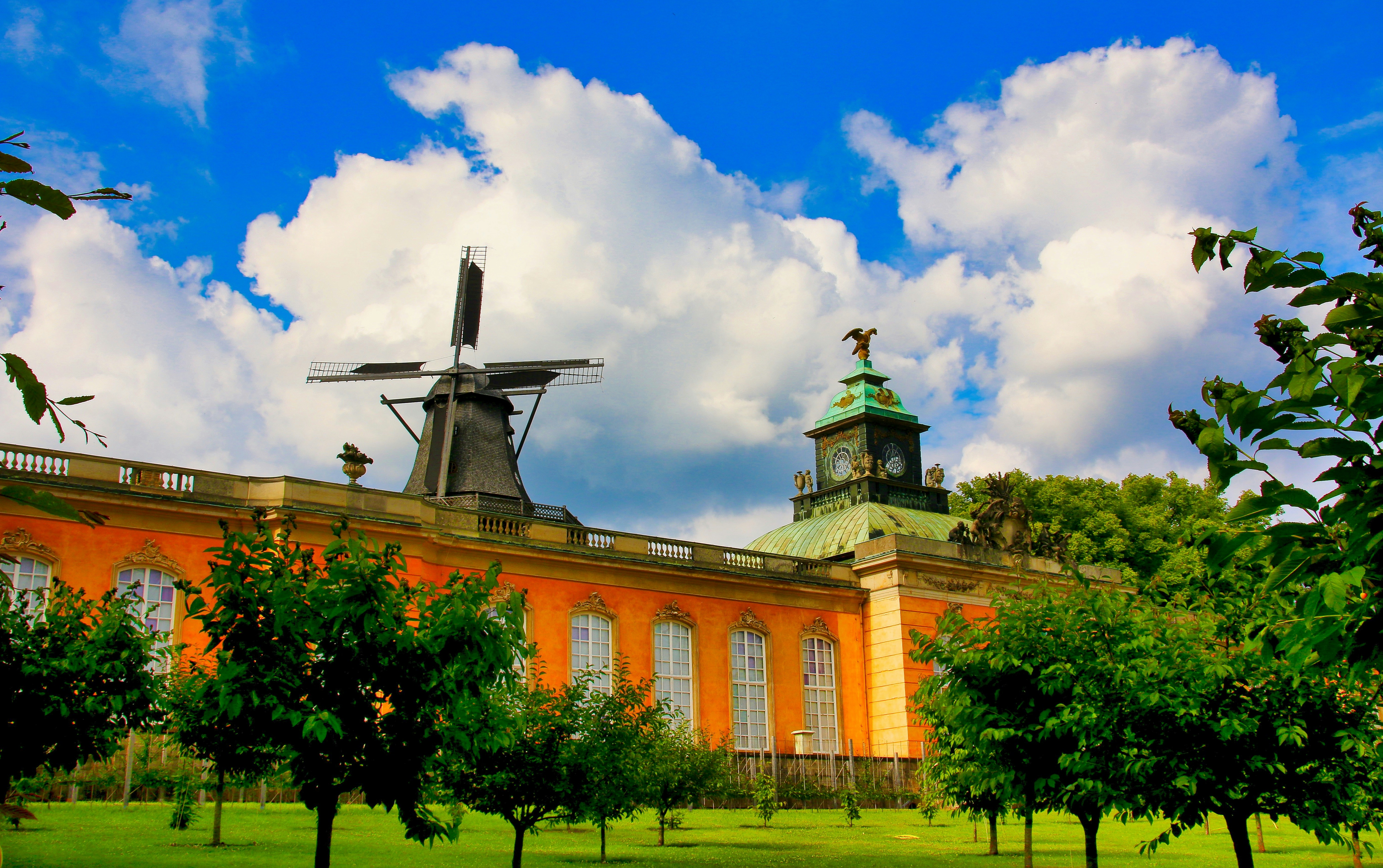 Turreted Pastel: A Windmill and Clocktower in a Sunlit Orange Courtyard