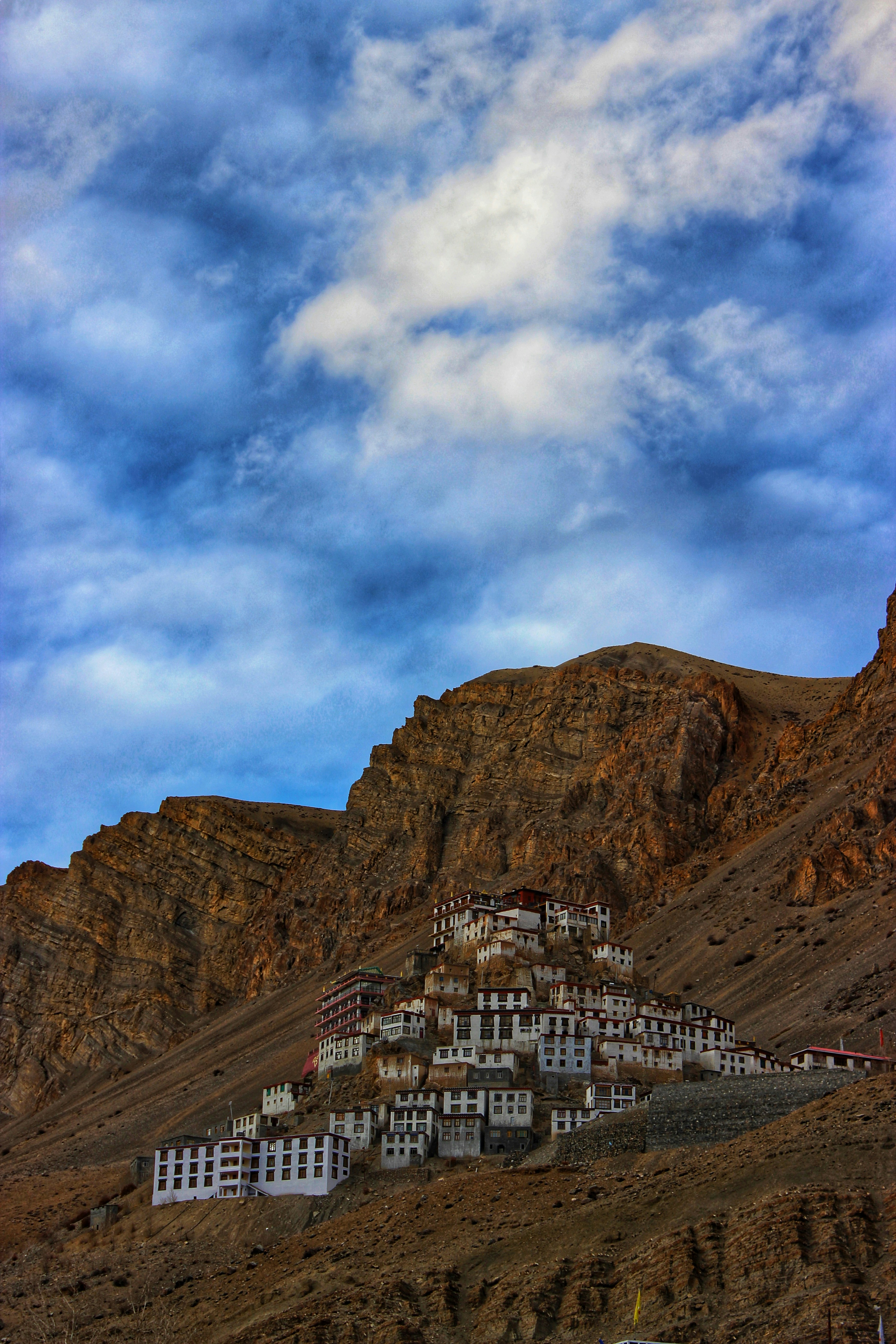 Terraced Monastery Clinging to a Rusty Slope Under A Bluish Sky