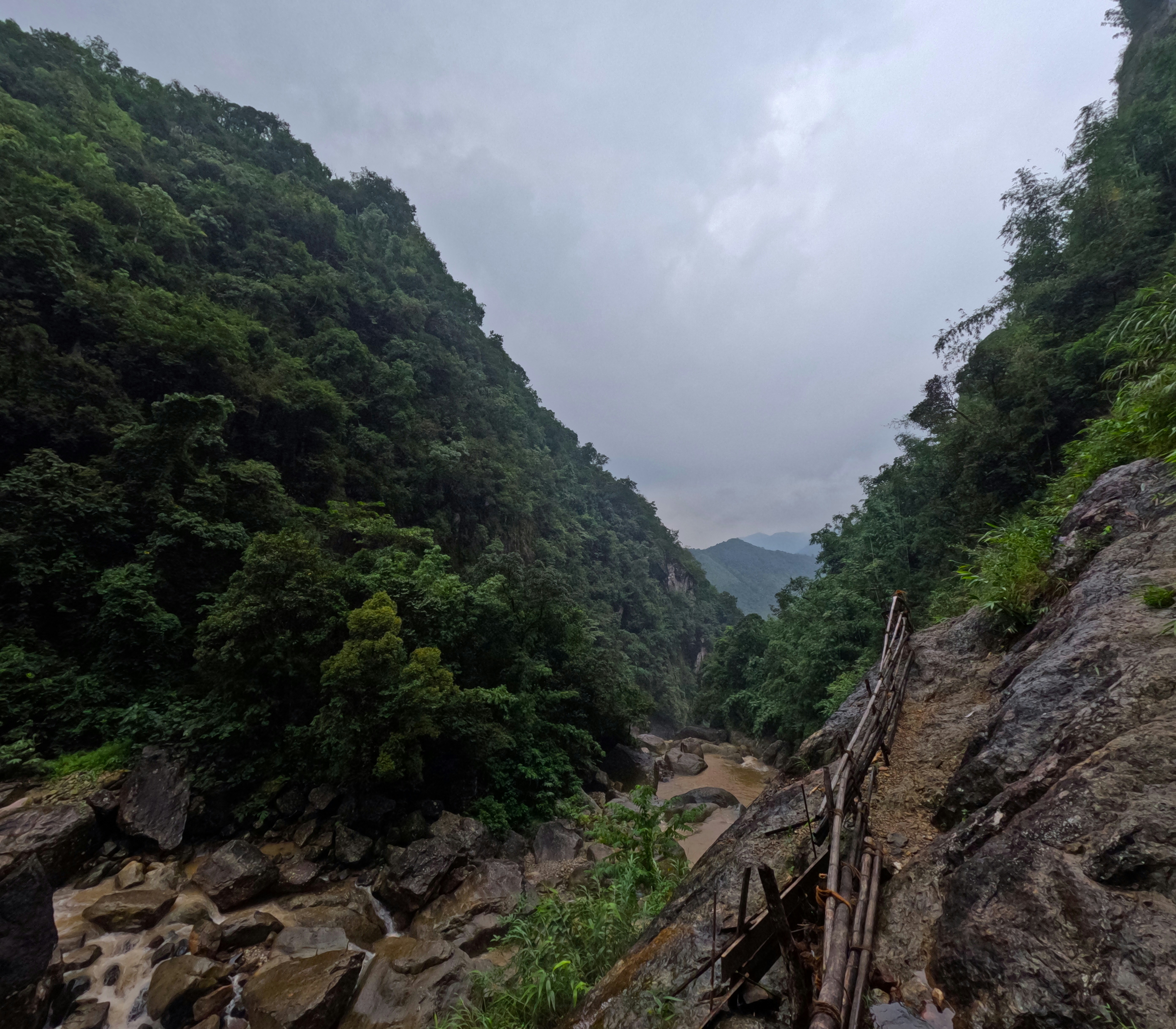 A narrow gorge with a river and a wooden path.