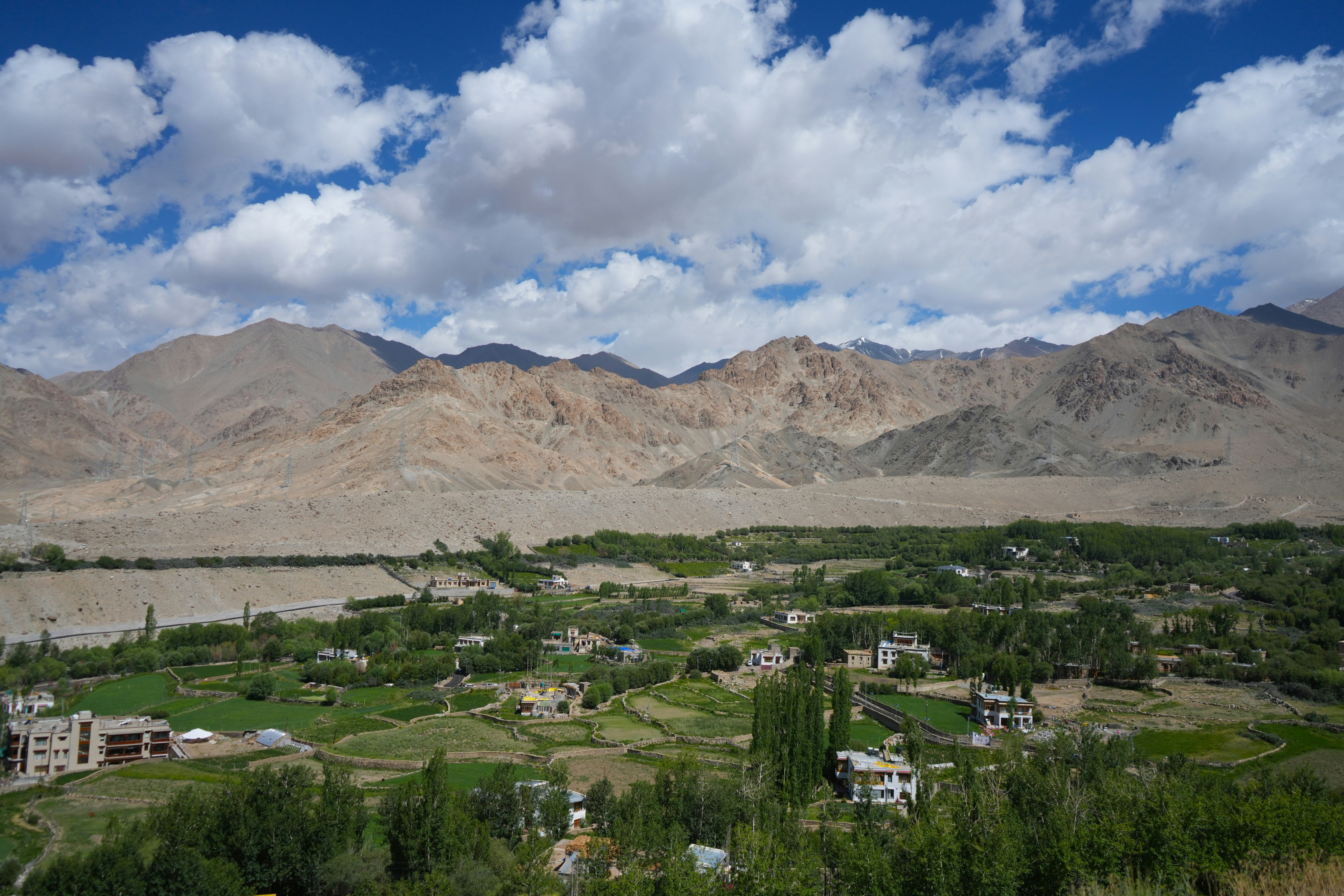Green valley with scattered houses and mountains beyond photo – Free Trees Image on Unsplash
