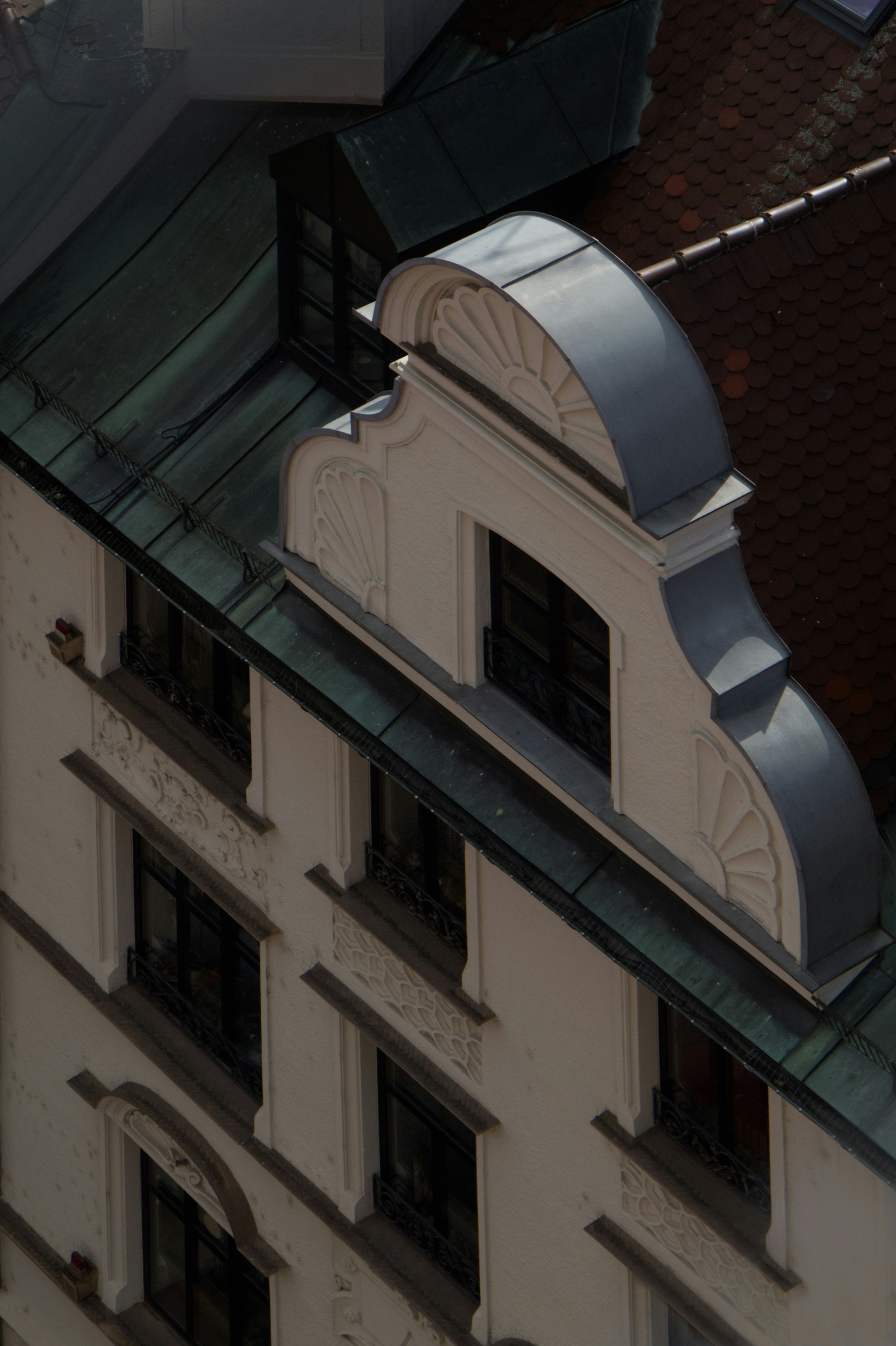 Ornate rooftop Combs: Architectural Detail on a Slanted Facade
