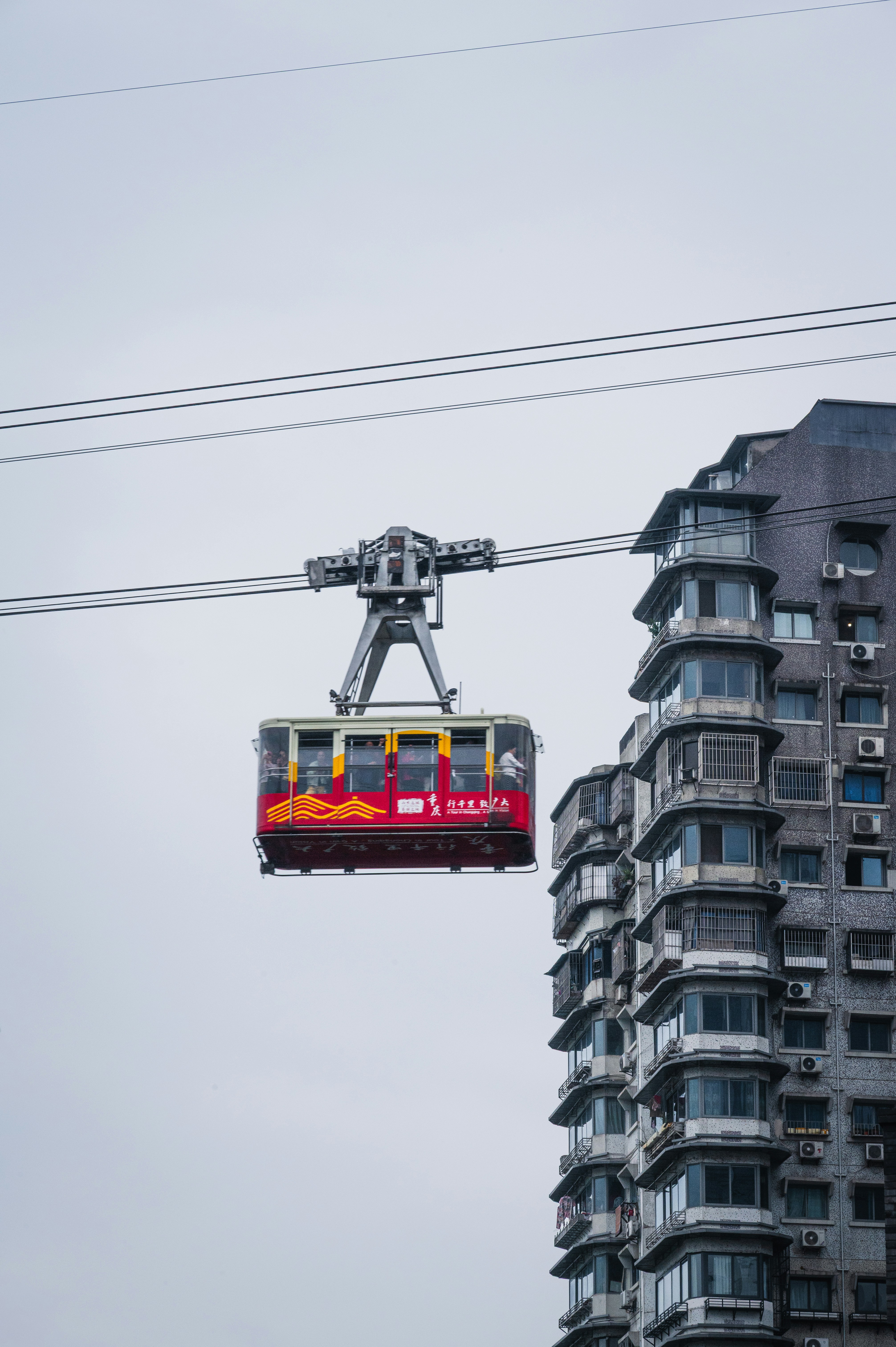 Cable Car Over City: A Red Car Amidst Urban Steel