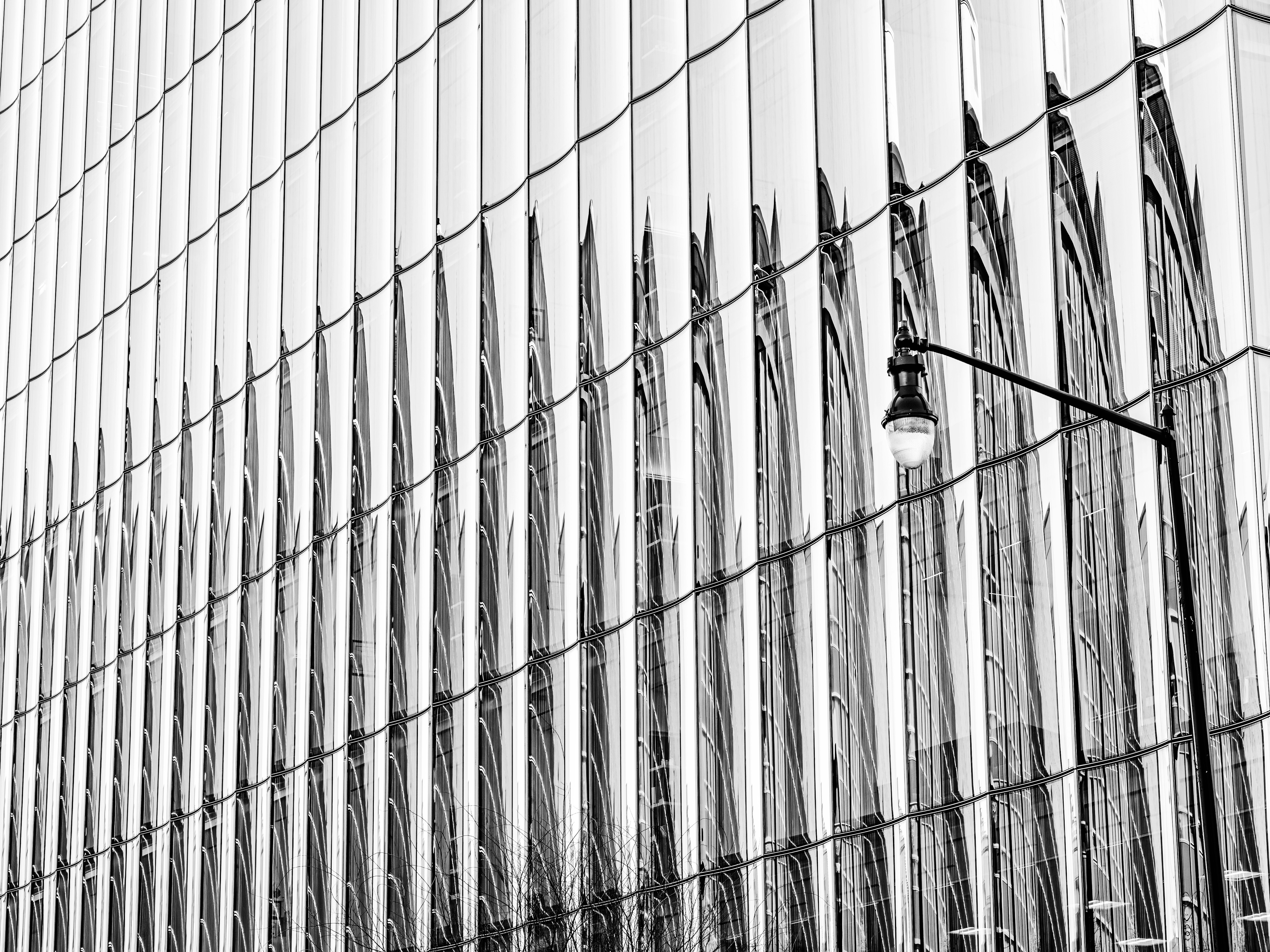 Wireframe Facade: Vertical Slats and a Streetlight in Monochrome