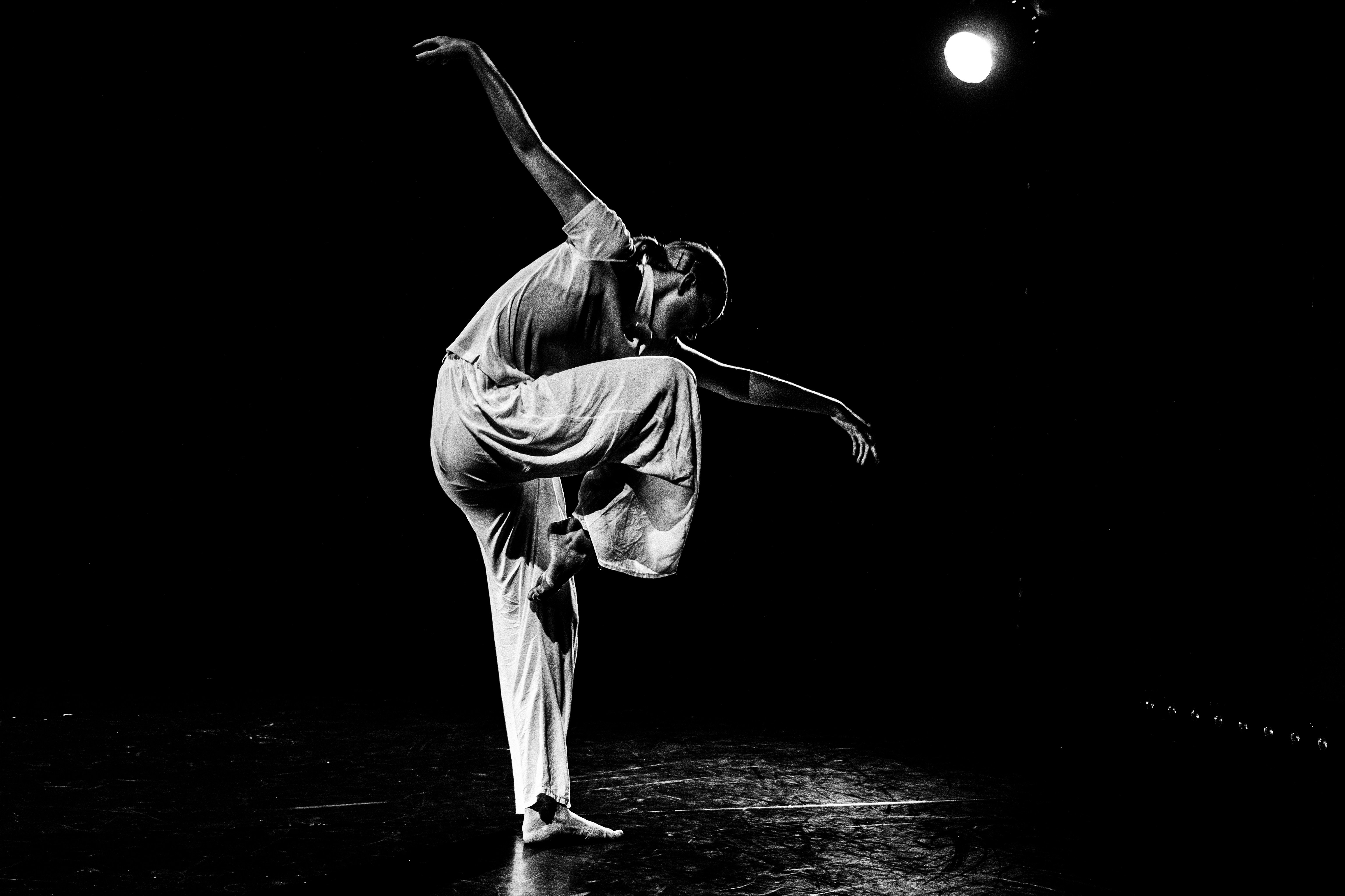 Moonlit Arc: A Dancer Suspended Between Ground and Spotlight