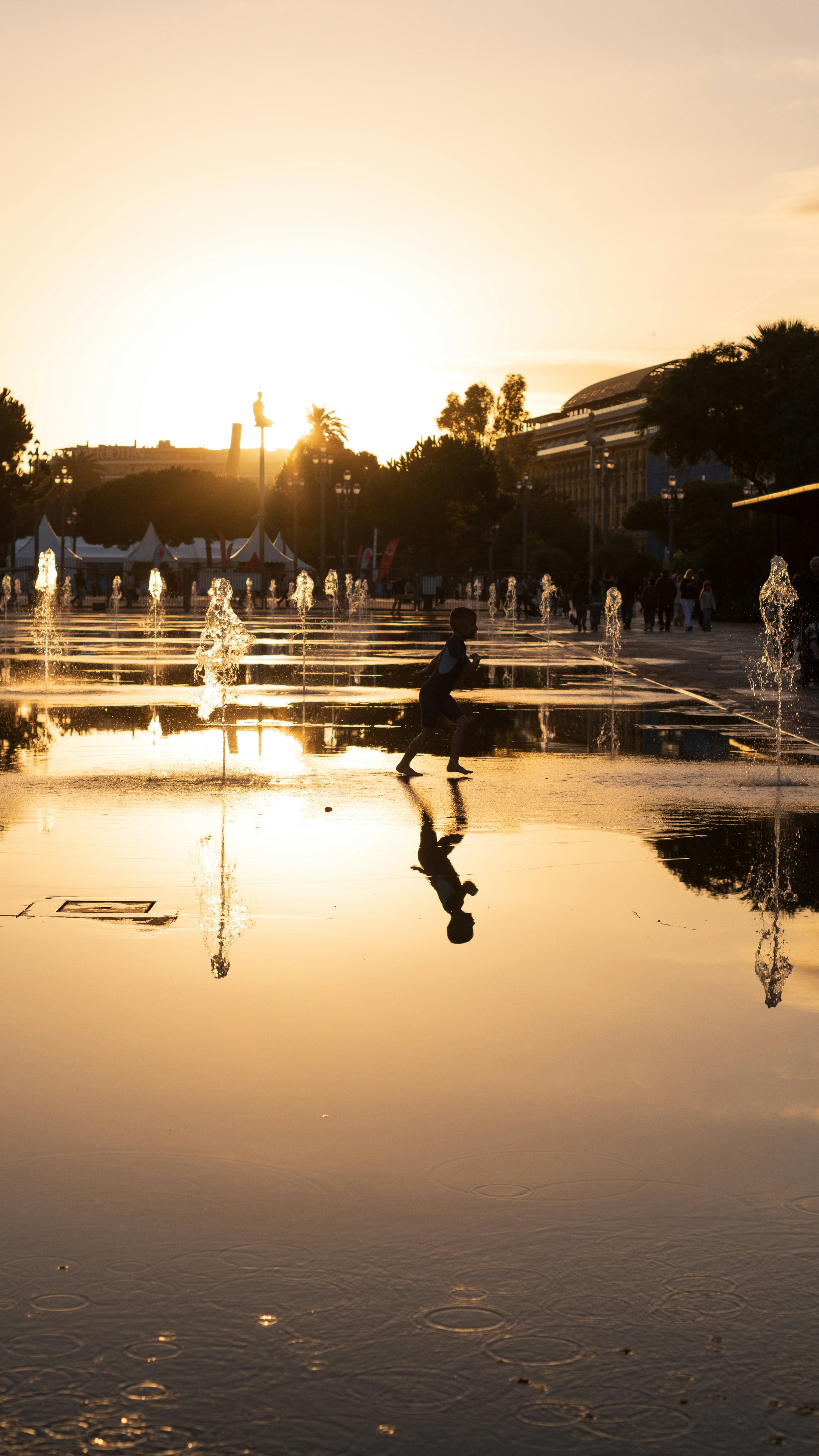 Sunlit Plaza Fountain: A Runner in a Golden Hour Echo