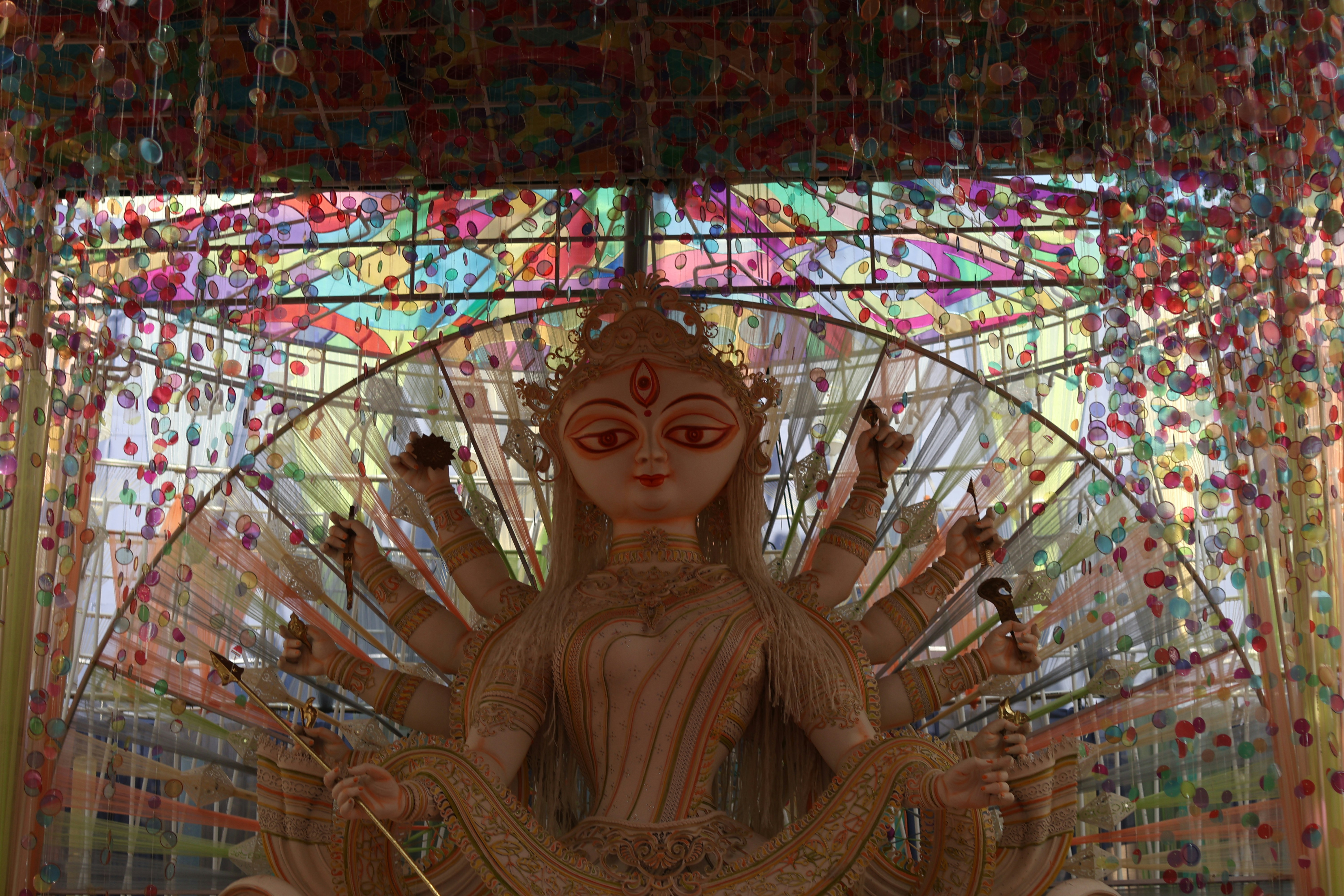 Multi-armed Reverence: A Sacred Statue Framed by Colorful Ornaments