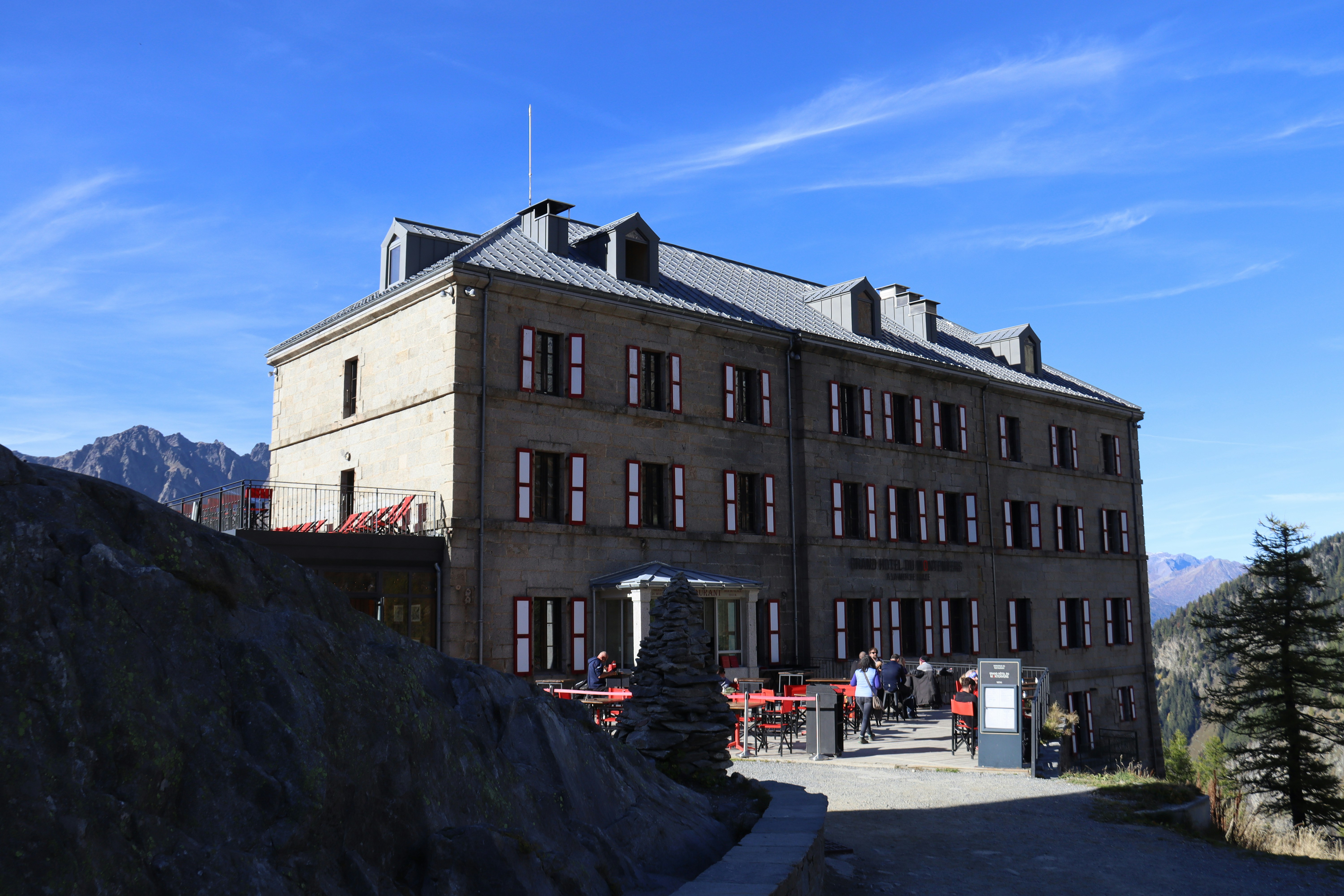 Alpine Lodge Footprint: Stone Block and Red-Table Terrace Under Clear Sky