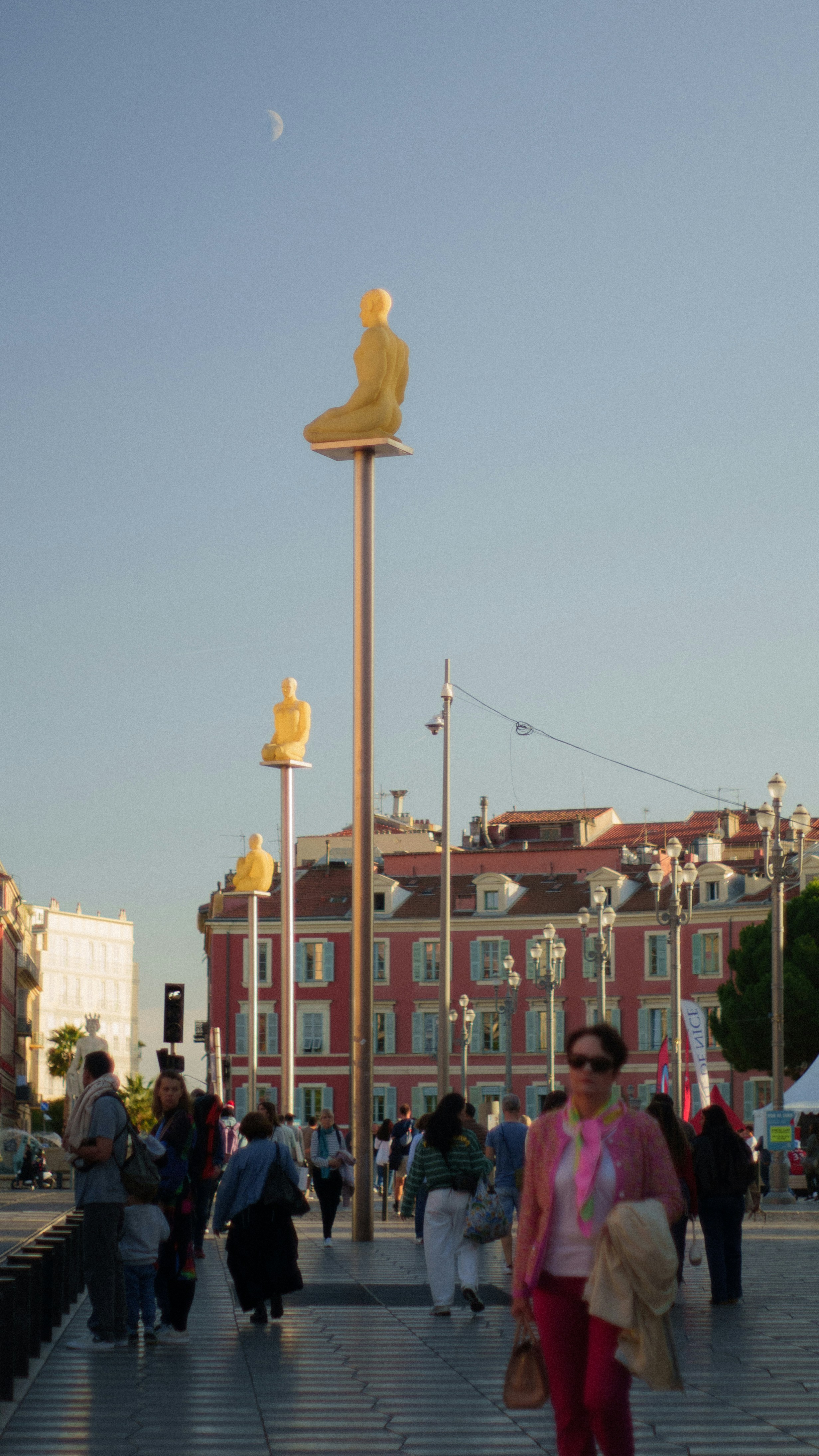 Statues on Pillars Overlook a Busy Boulevard