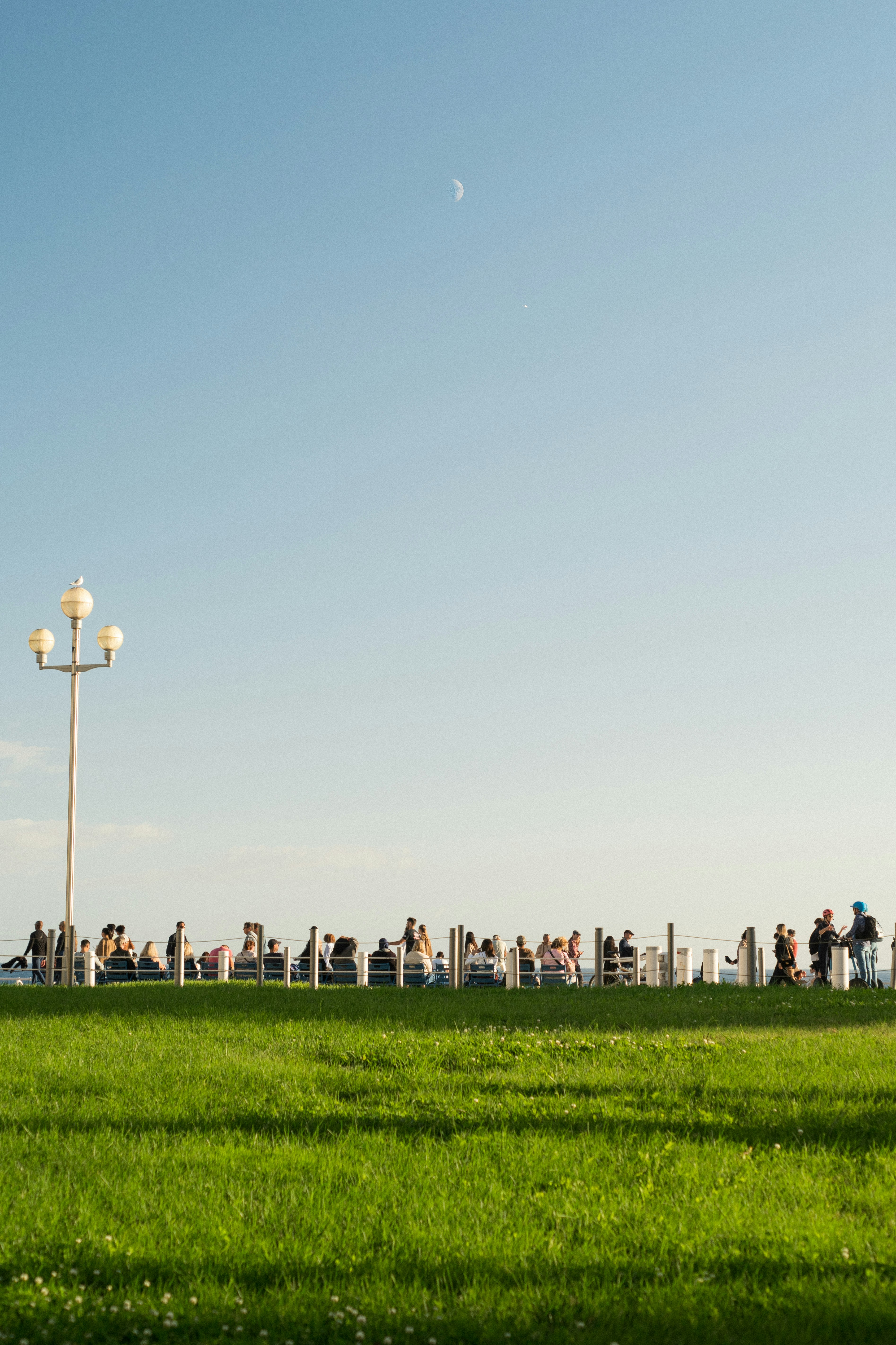 A quiet waterfront promenade under a pale blue sky