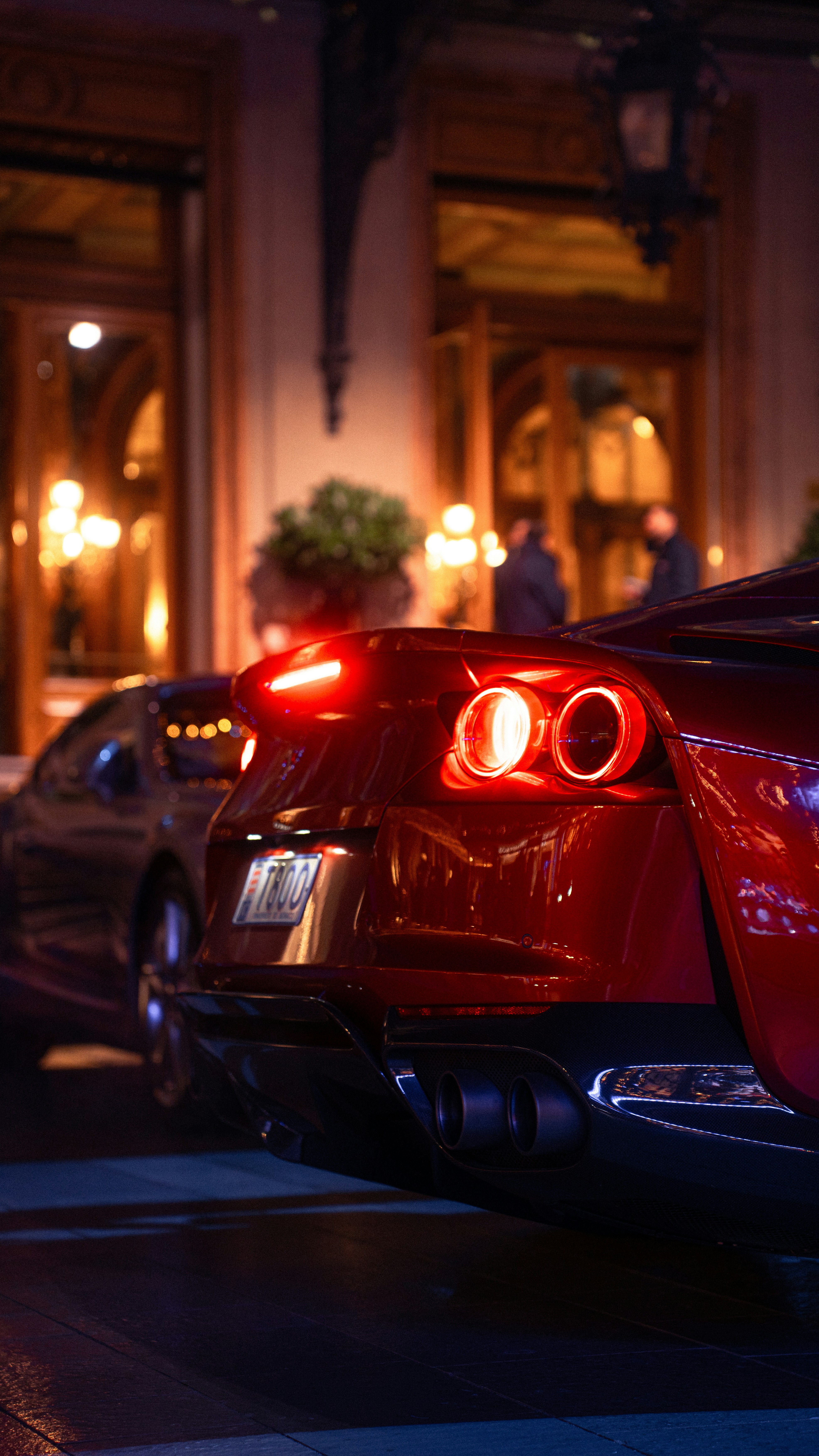 Red taillights and chrome curves: nocturnal city silhouette
