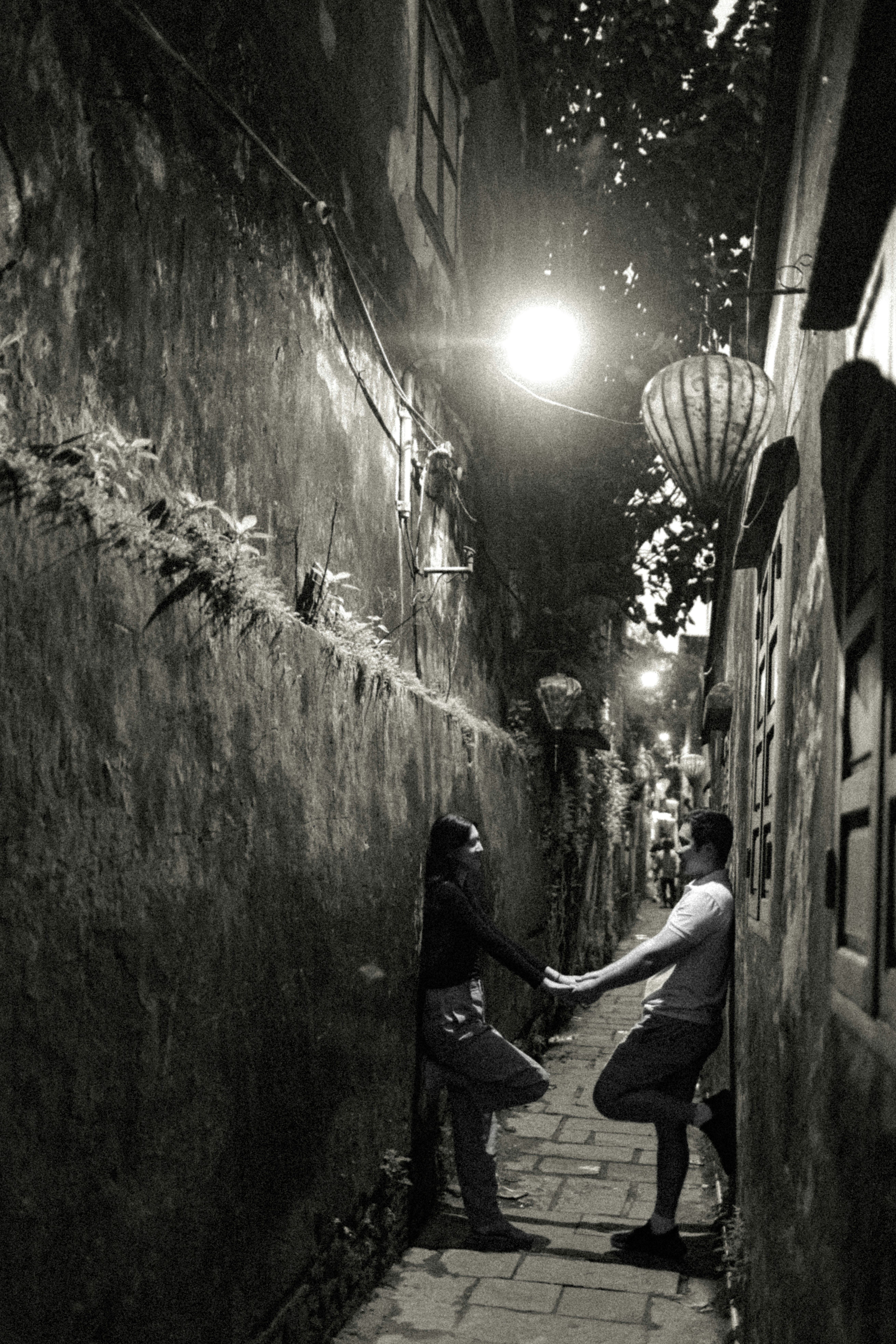 Hands Reaching Across the Alley: A Quiet Connection in Mono