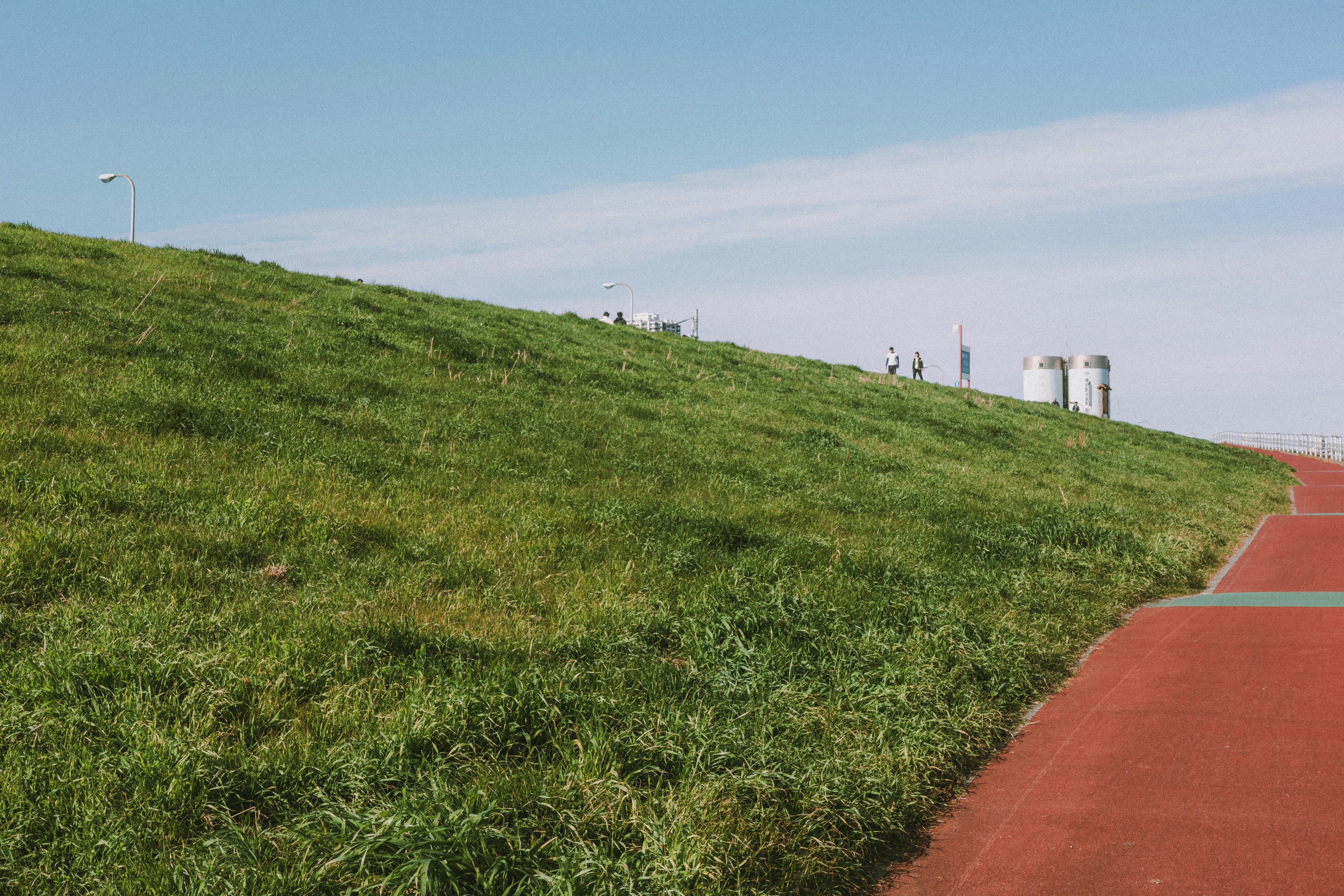 Slope, Path, and Distant Silos: A Quiet Coastal Walk