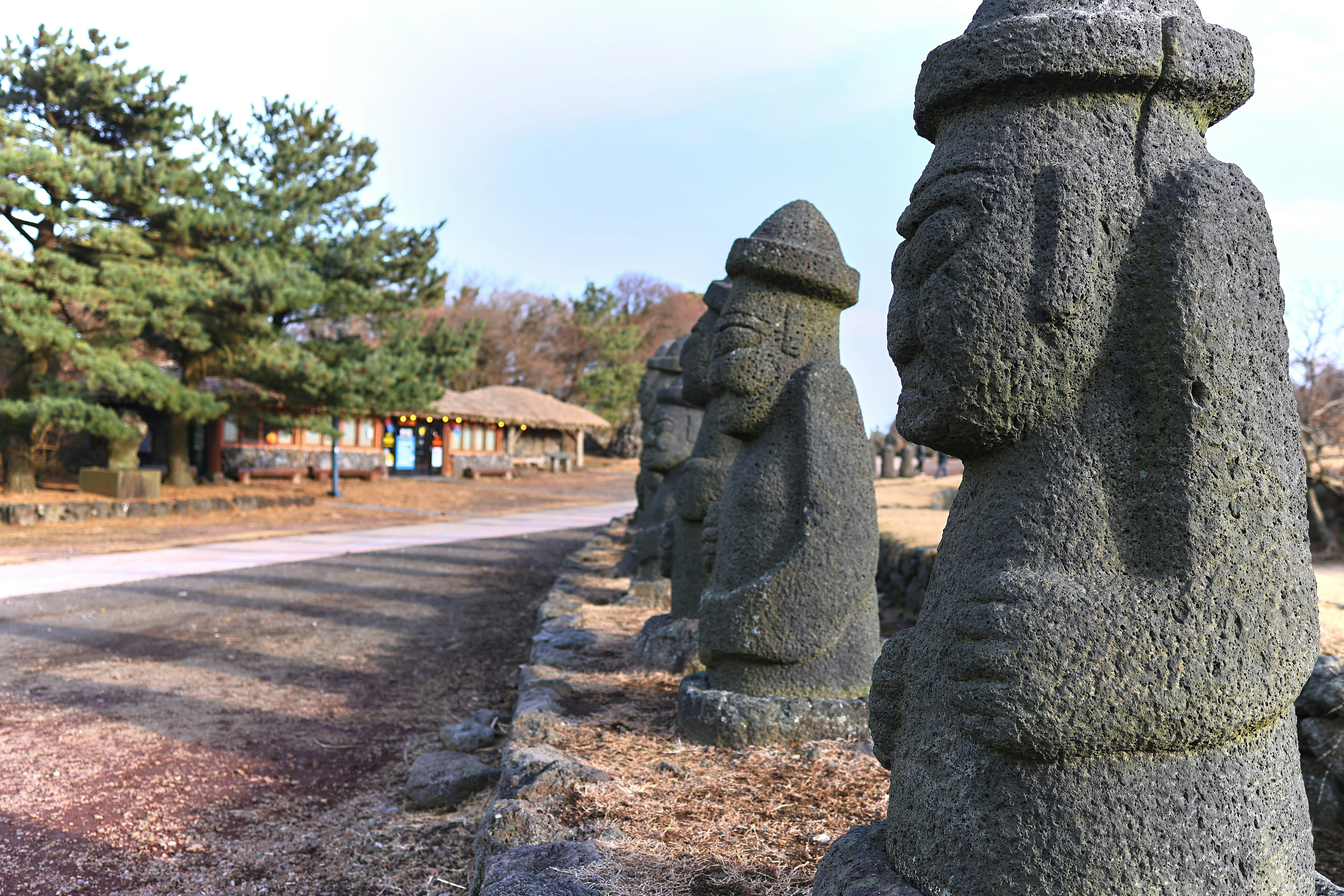 Row of ancient stone guardians marching toward the park gates