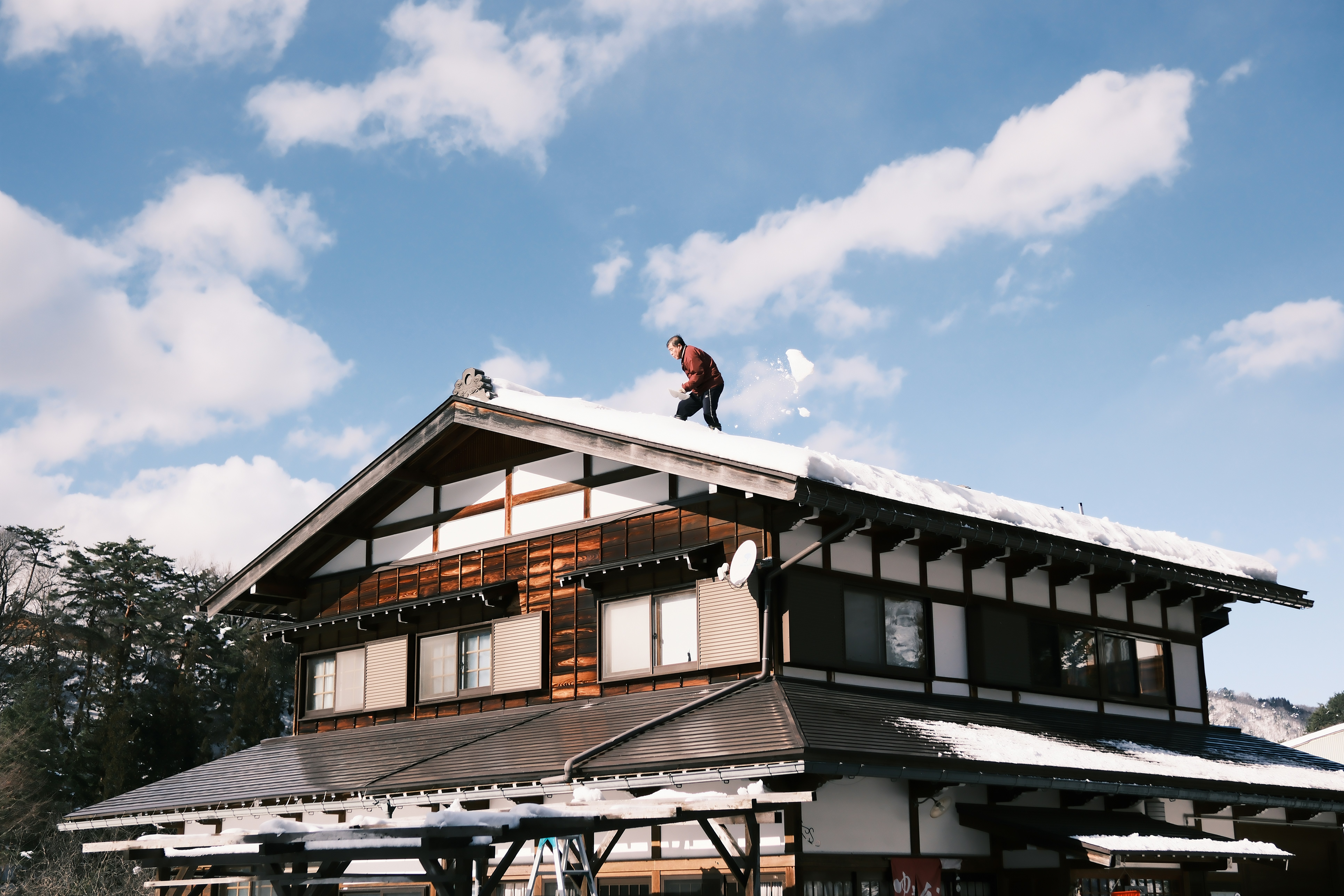 Snowbound Rooftop Moment: A Skier Perches on the Peak