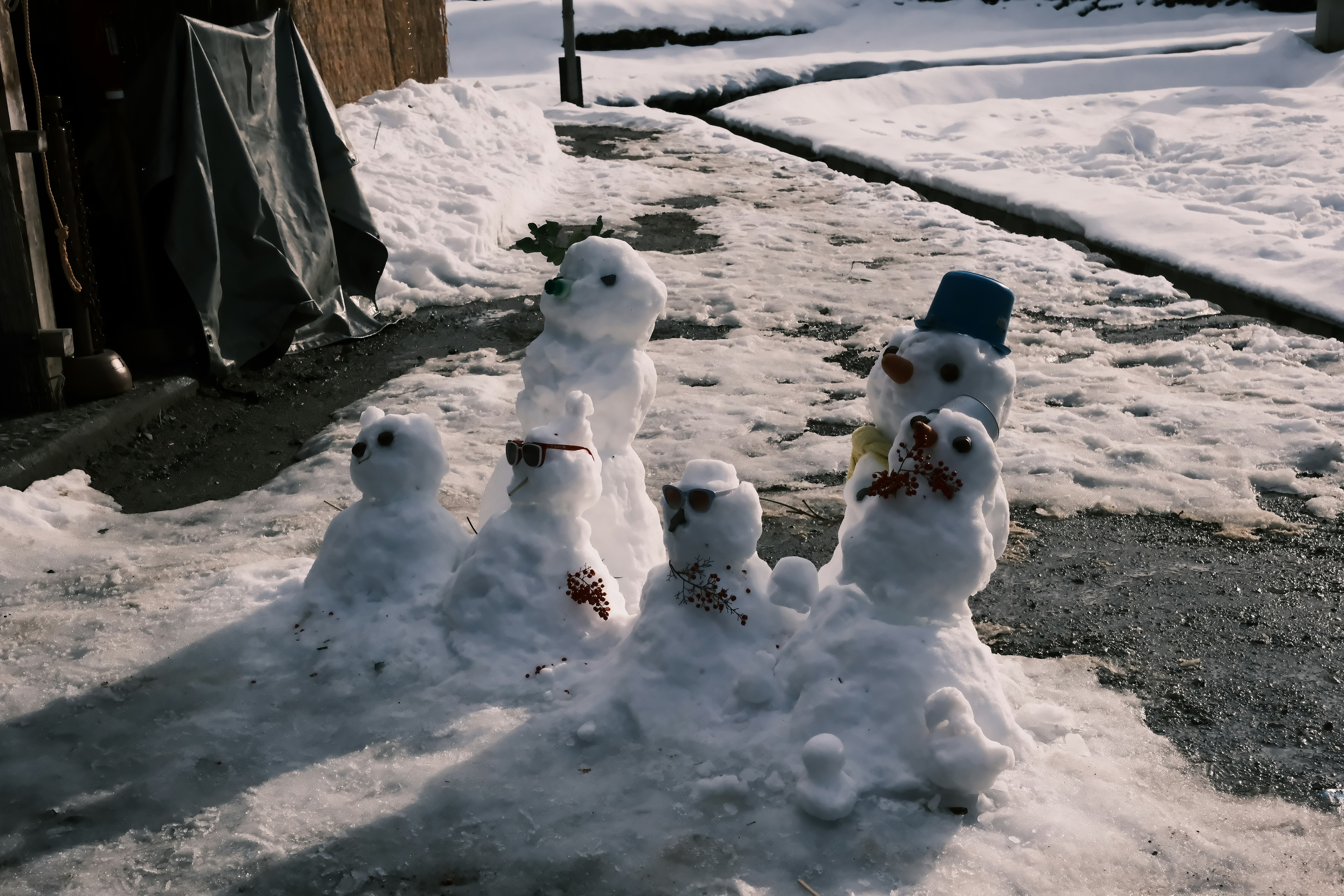 Snowy Assembly: A Row of Cheerful Snowmen Anchored by a Dark Leafless Path