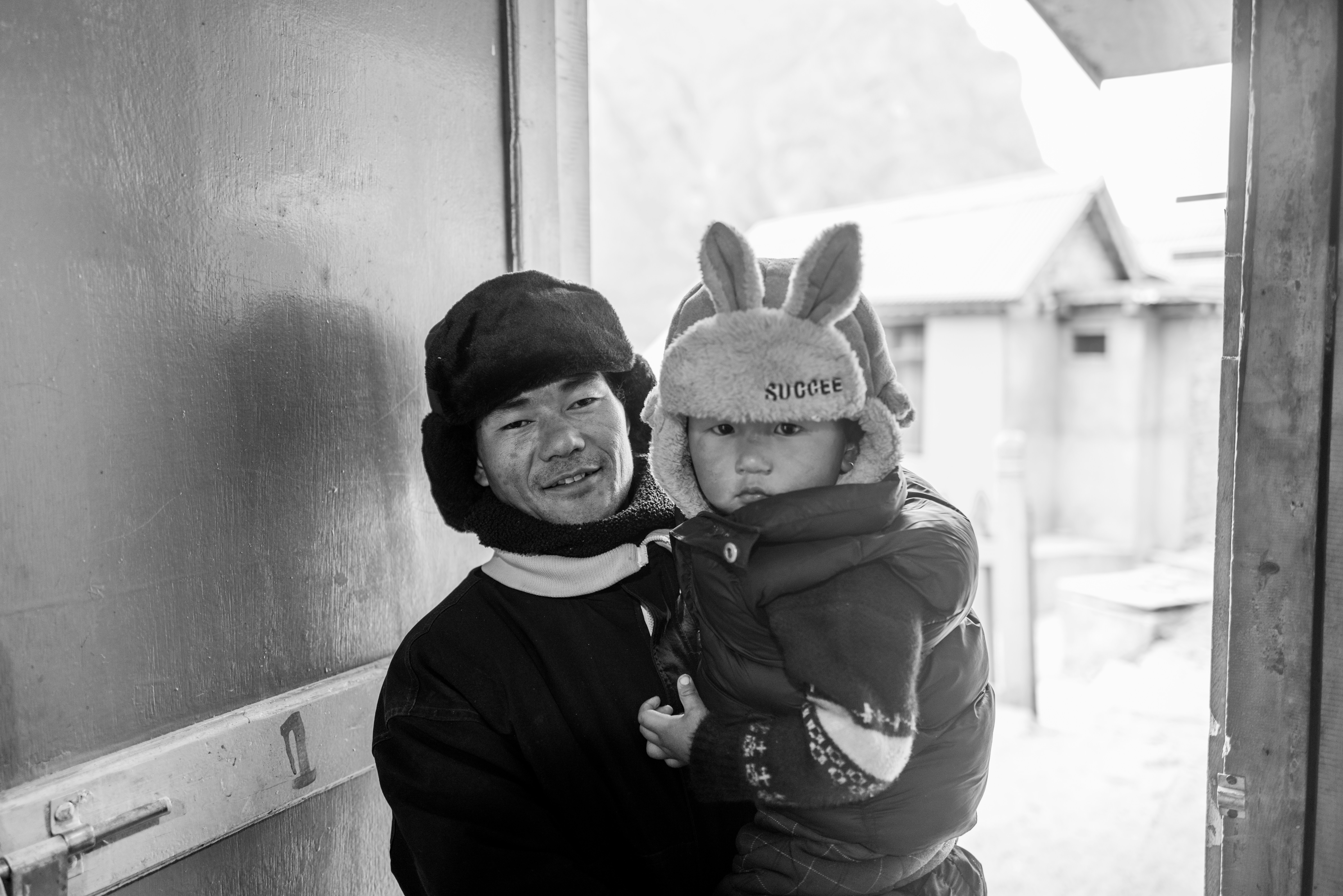 A Quiet Moment: Father and Child in a Liminal Doorway