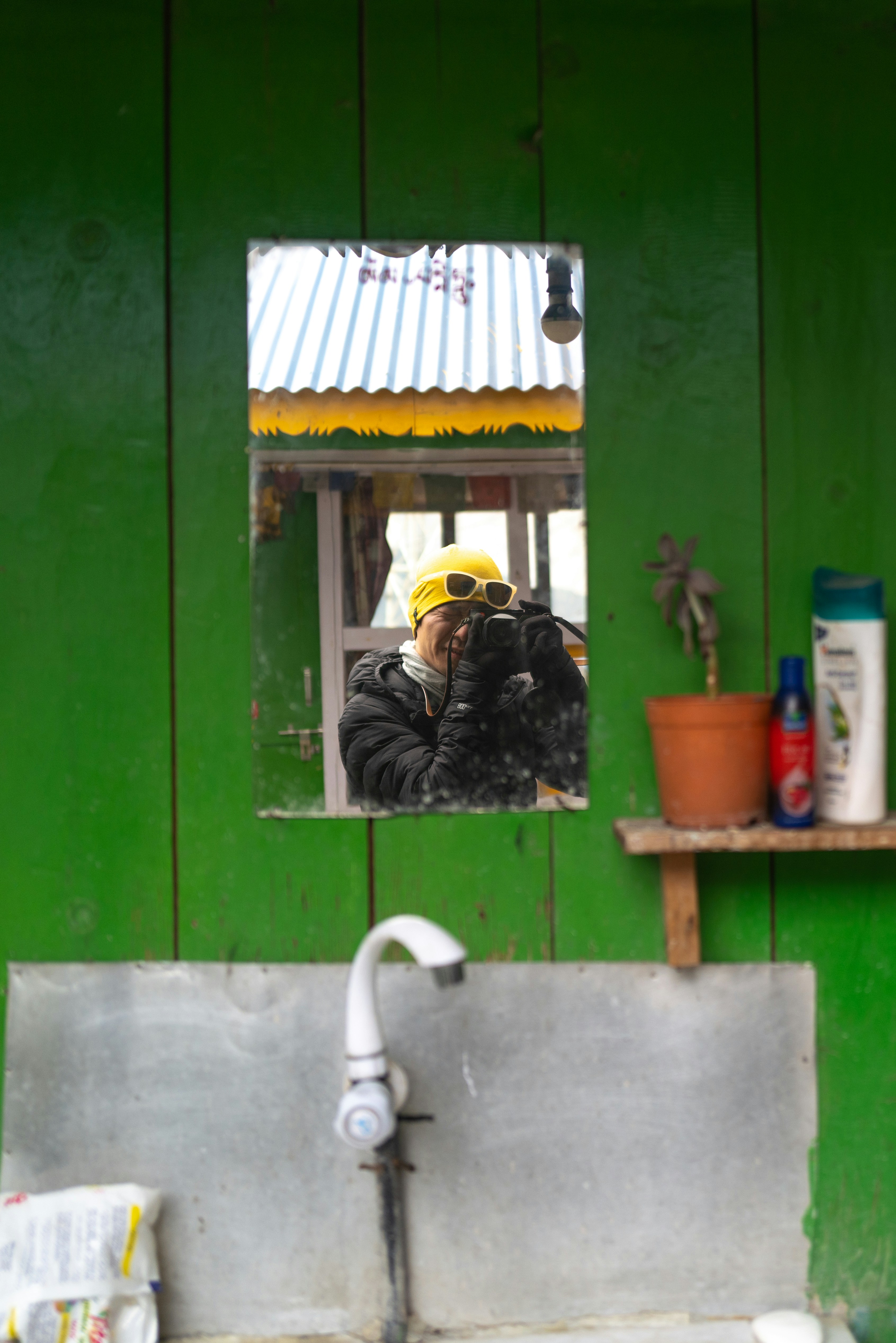 Green-Walled Workspace: The Reflective Self-Portrait by the Sink