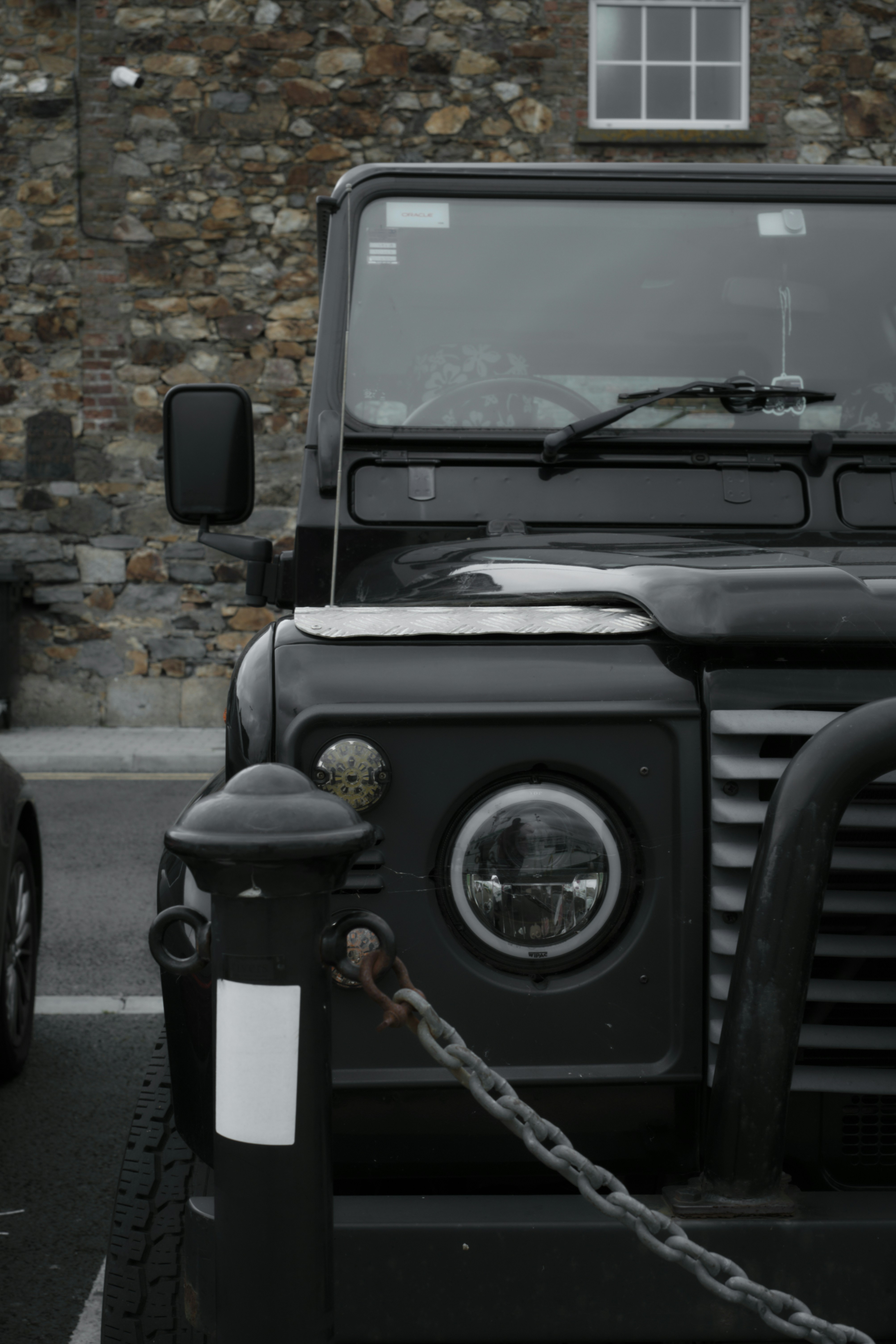 Front-Facing Grit: A Dark Jeep at the Edge of the Street