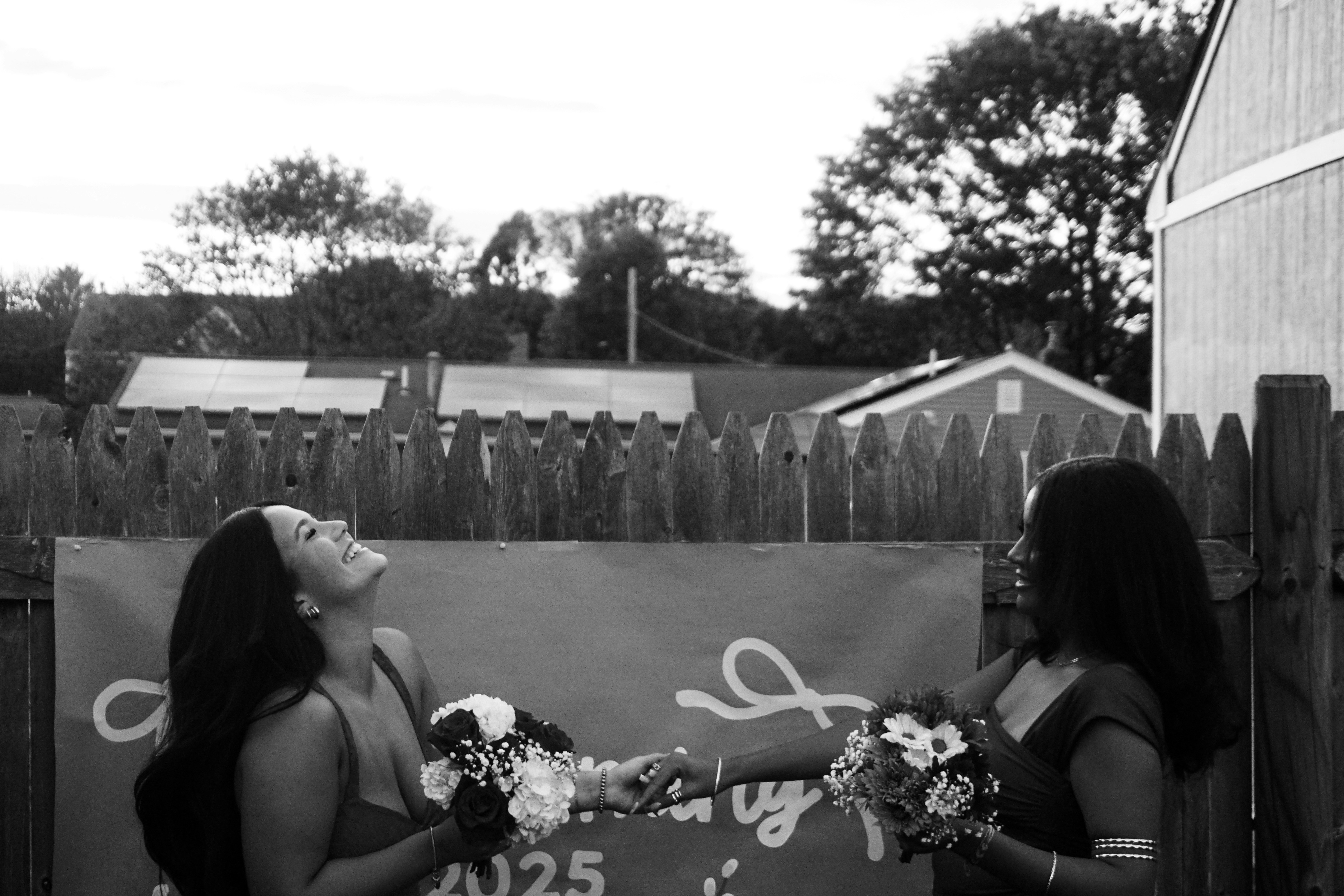 Two Brides, One Moment: Bouquet Exchange Under a Sunny Fence