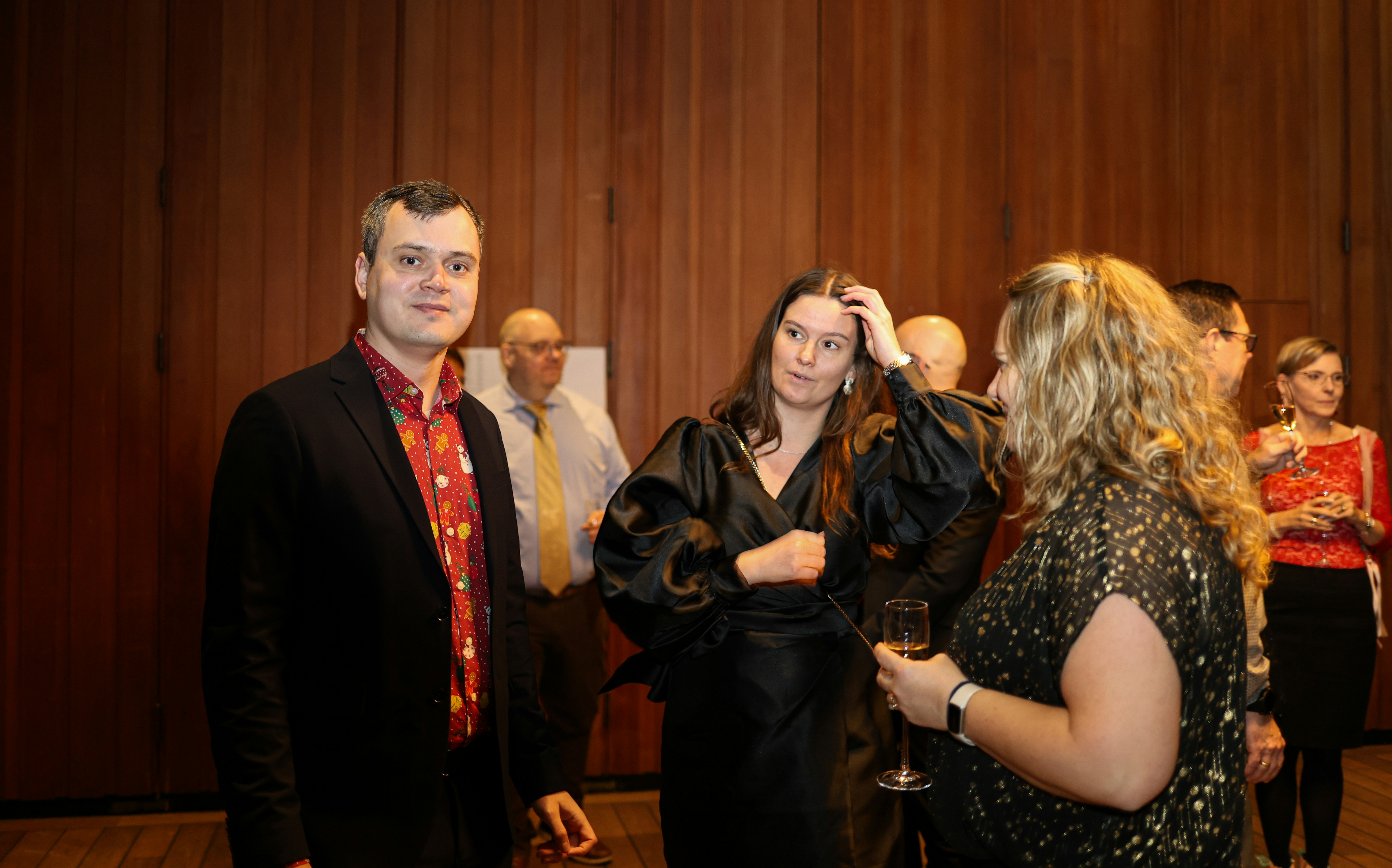 Spotlight at the Mixer: A Man in a Red Tie and the Conversational Crowd
