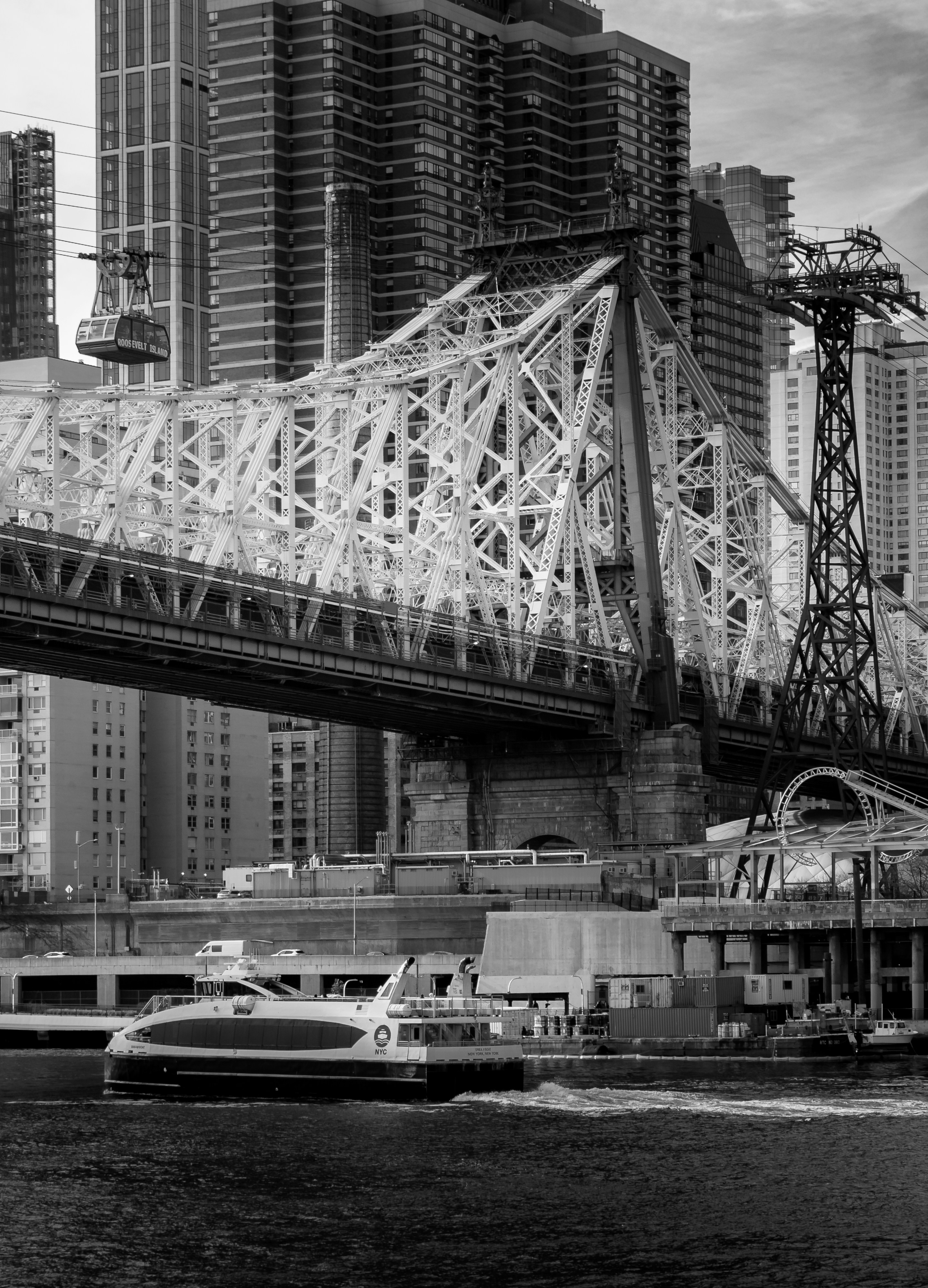 Steel Skyline and River Wake: A Black-and-White Moment Under the Bridge