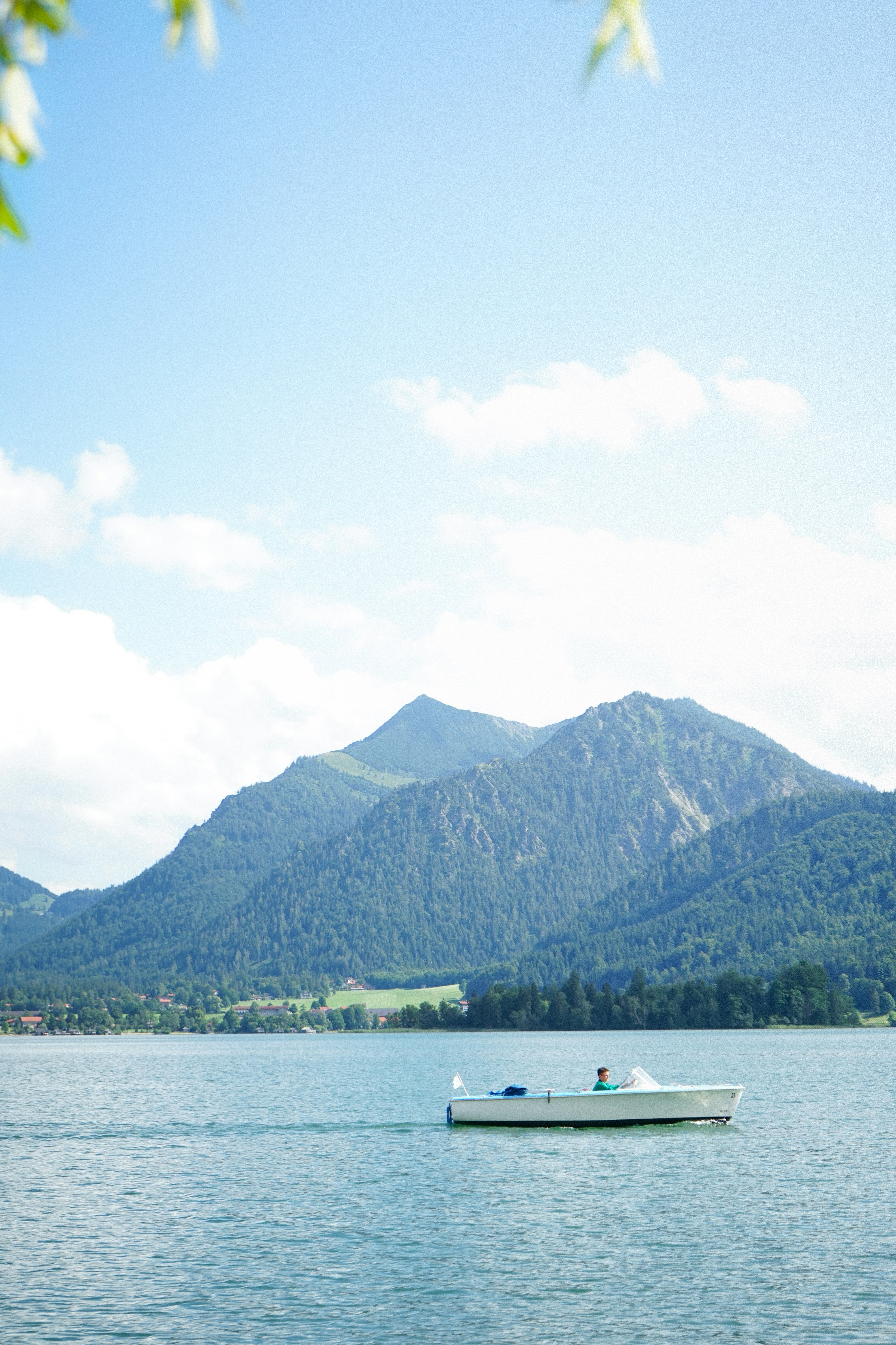 Calm Lake Crossing: A Lone Boat Beneath Alpine Skies