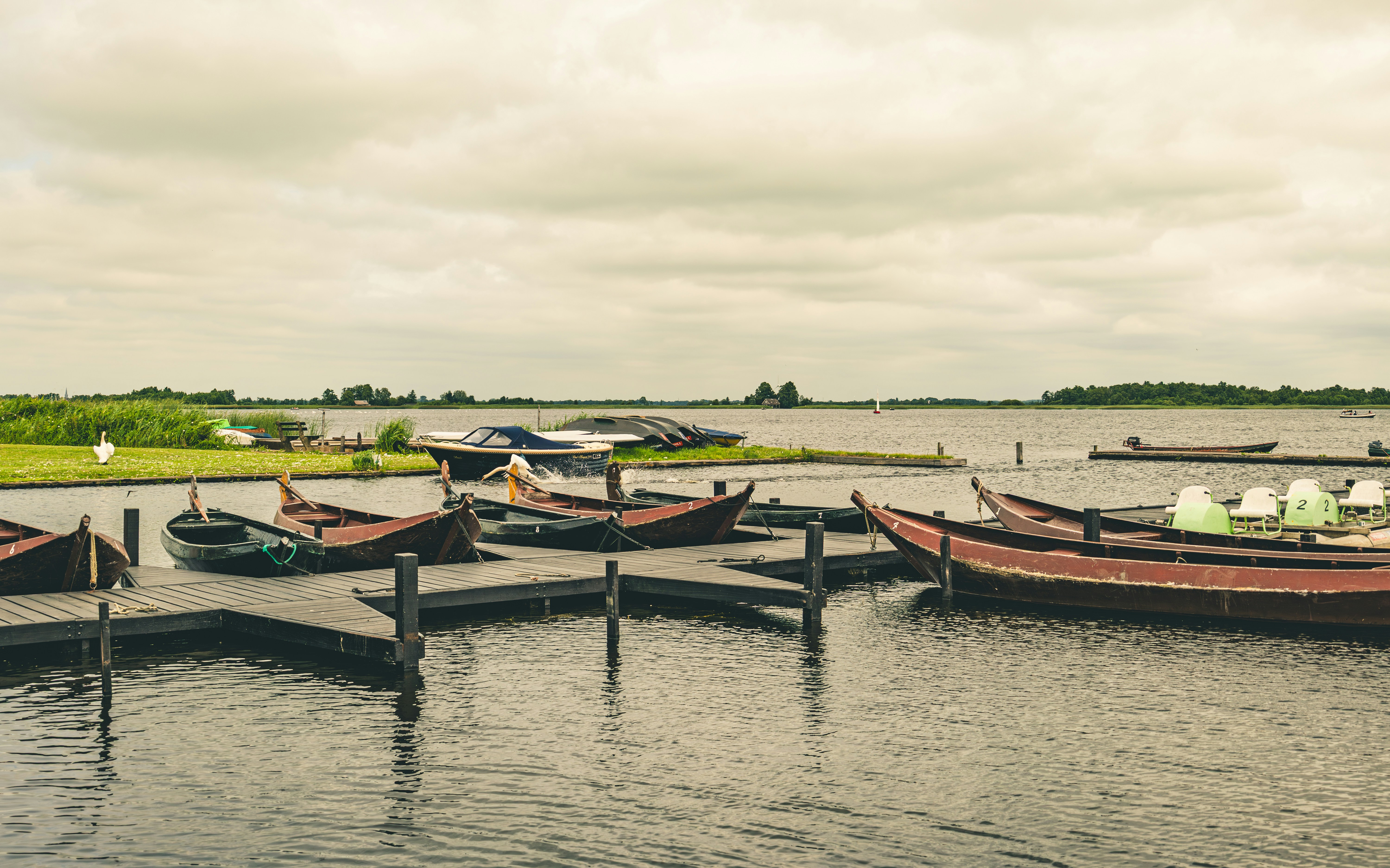 Harbor stillness: boats nudged along a lakeside jetty at dusk