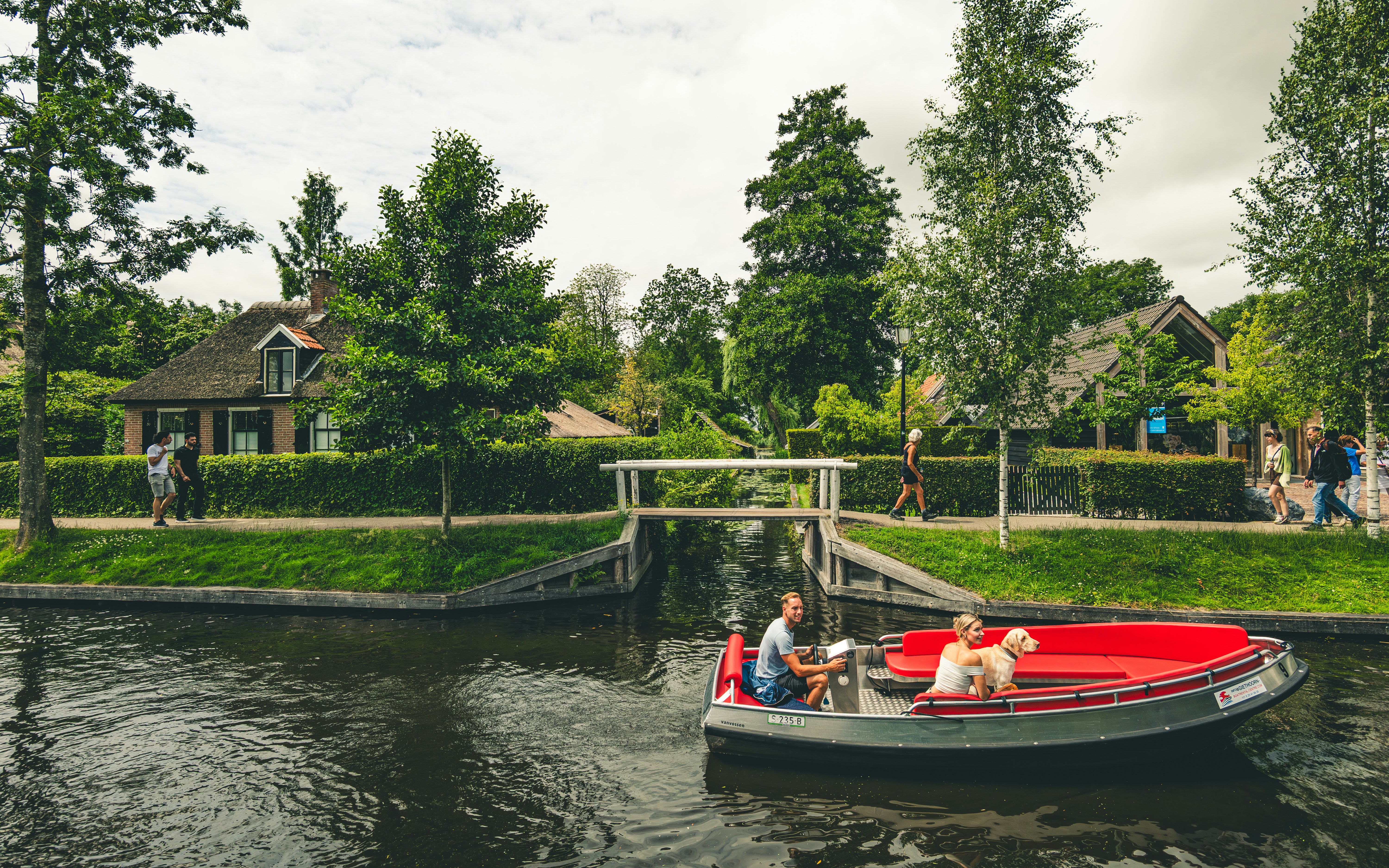 Boat Ride on a Calm Canal Beneath a Quiet Suburban Bridge