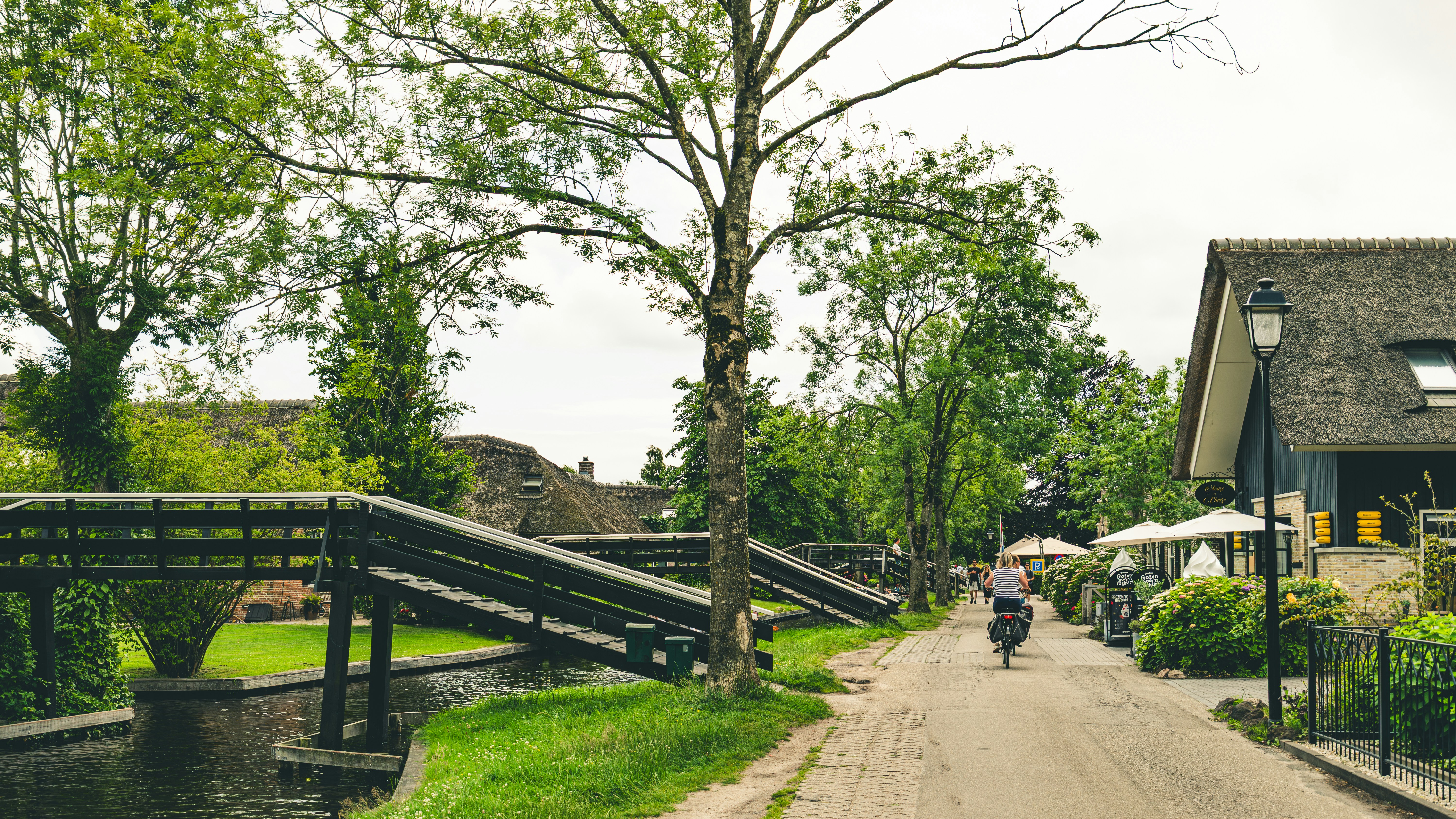 Quiet Riverside Pathway with a Pedestrian on a Timber Bridge