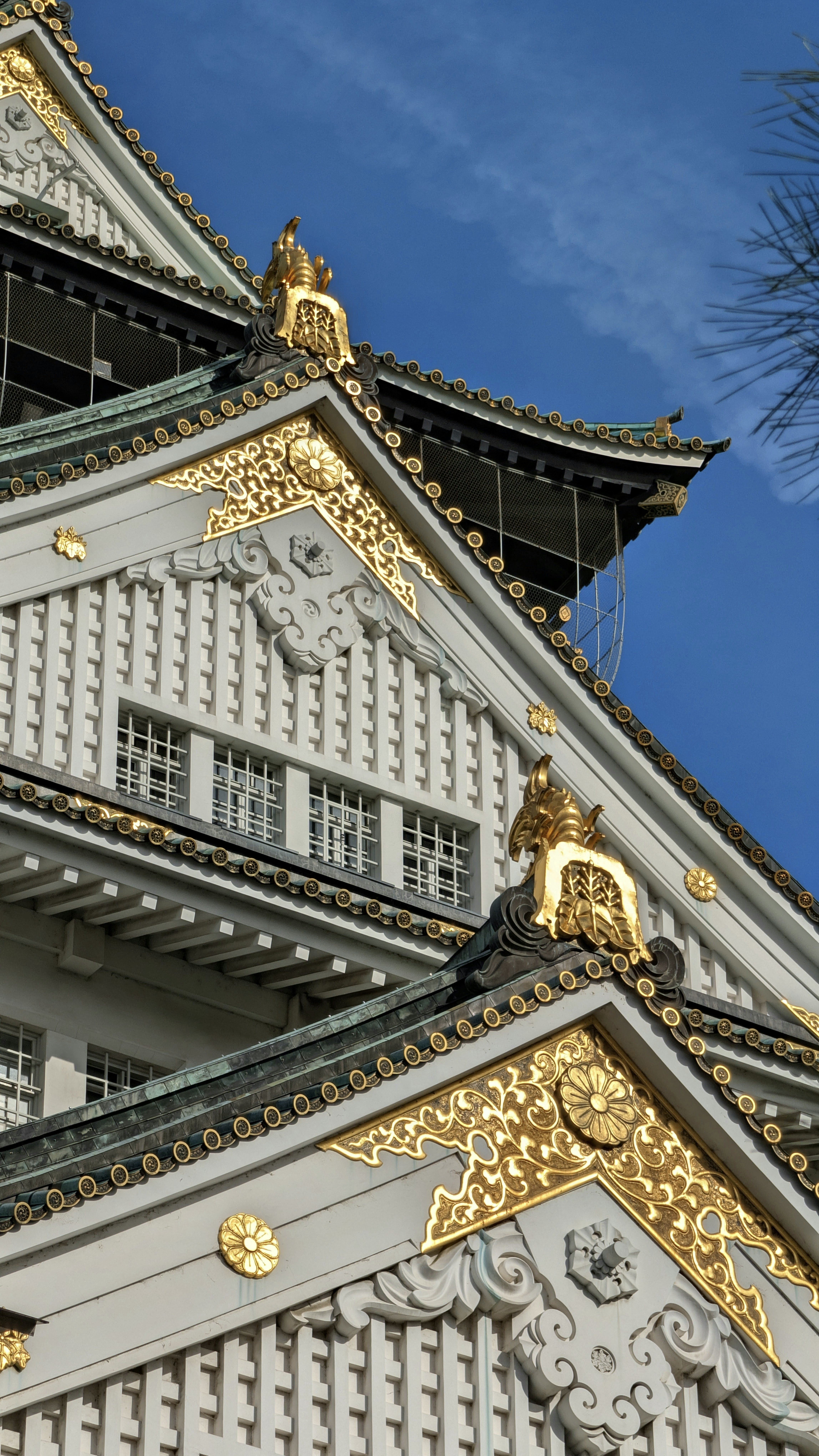 Golden Ornamented Rooflines: A Japanese Castle Facade Under a Cerulean Sky