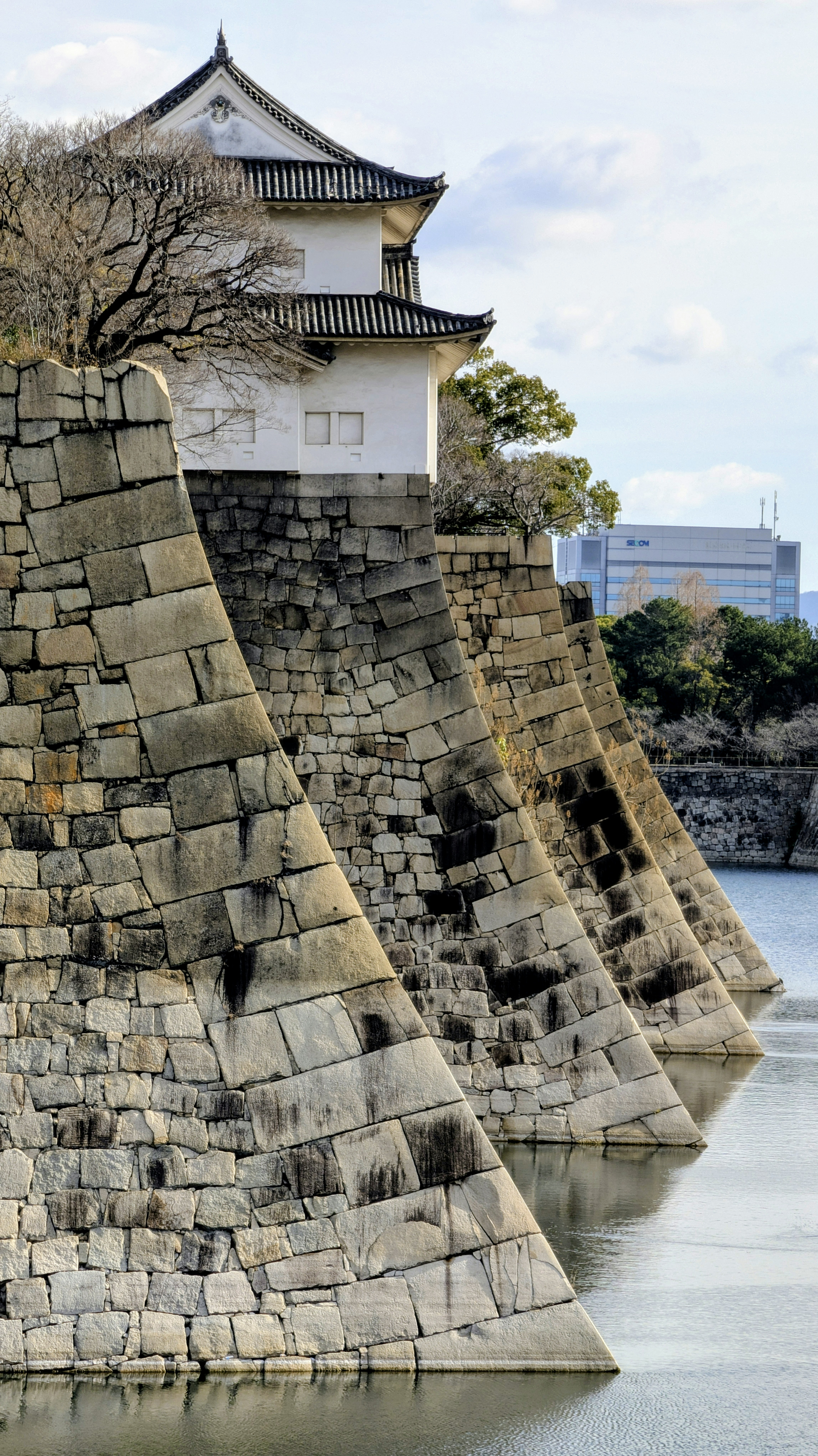 Stone Ramparts and White Watchtower Against a Foamy Sea
