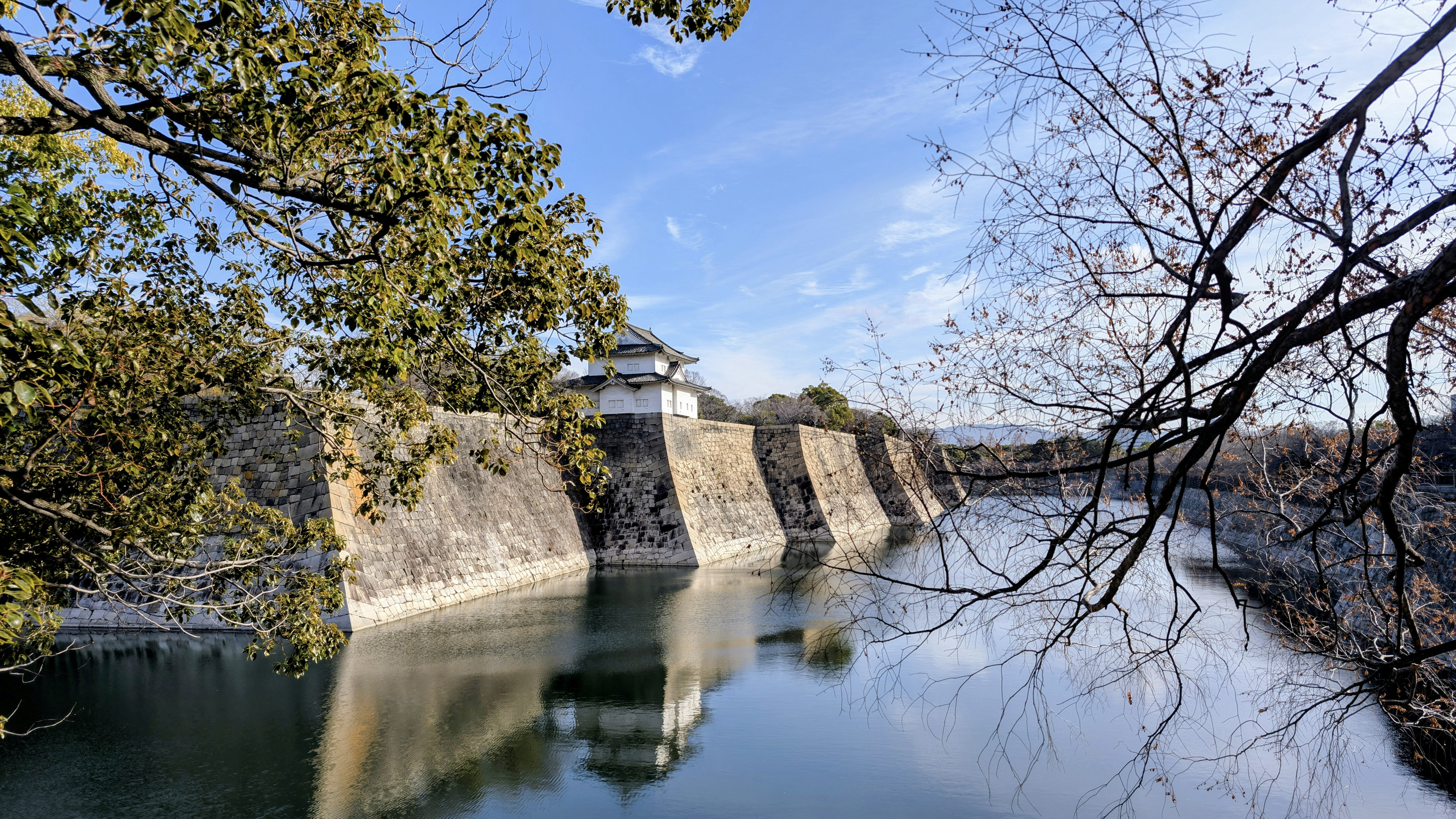 Stone Ramparts and Calm Reflections: A Riverside Fortress View