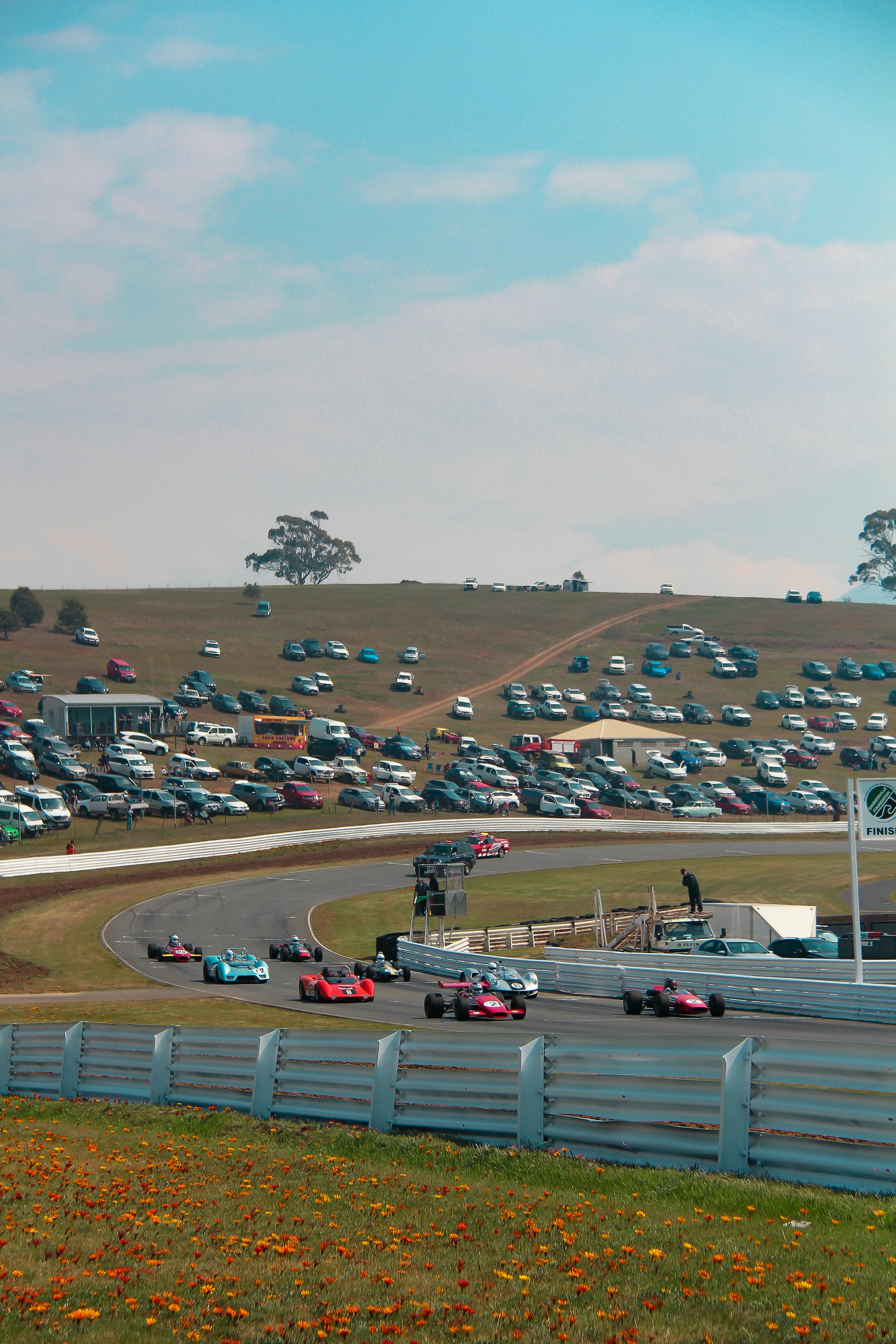 Race cars speed around a track with spectators watching. photo – Free ...