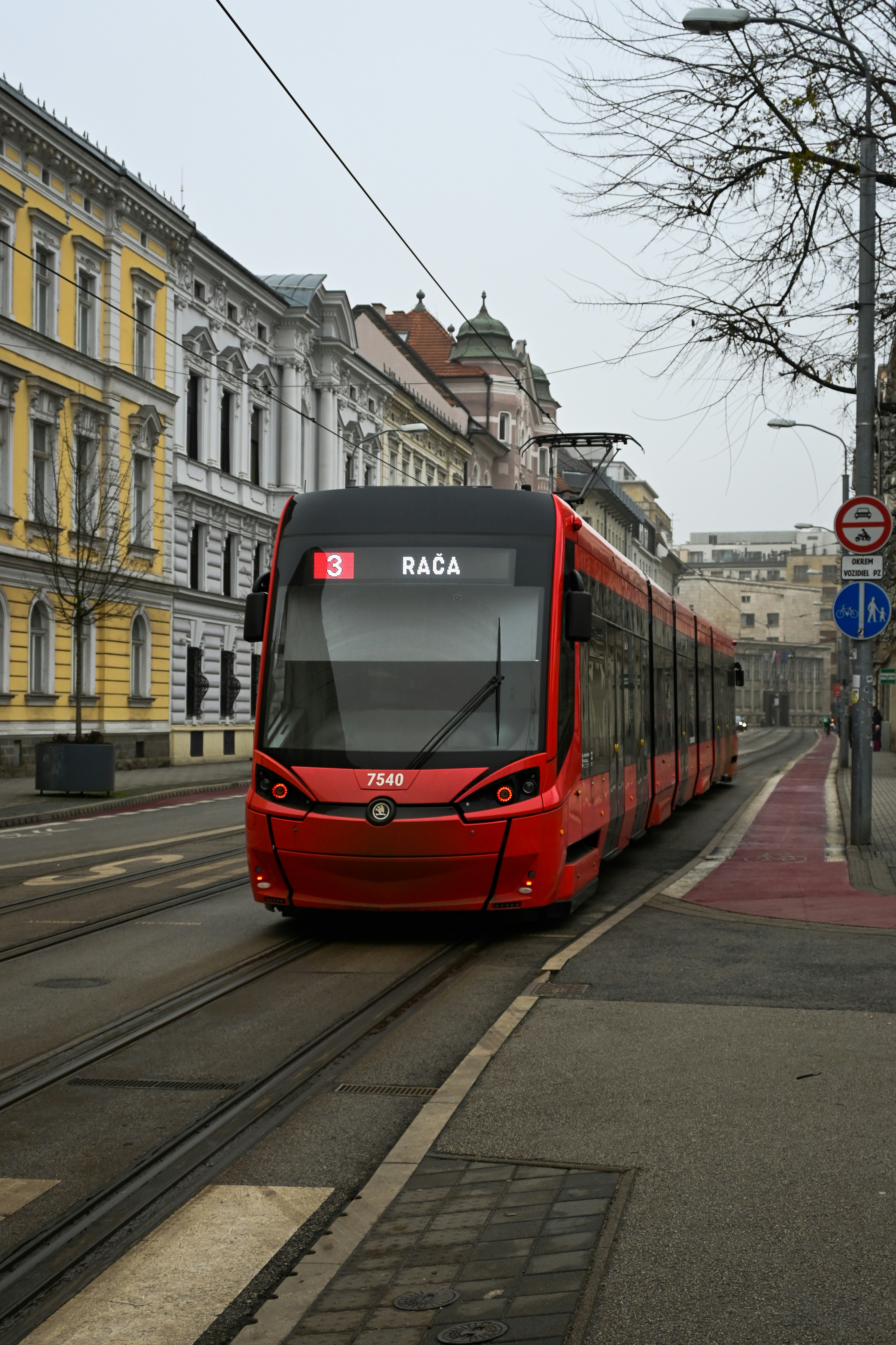 Red Tram Cutting Through a Historic European Street