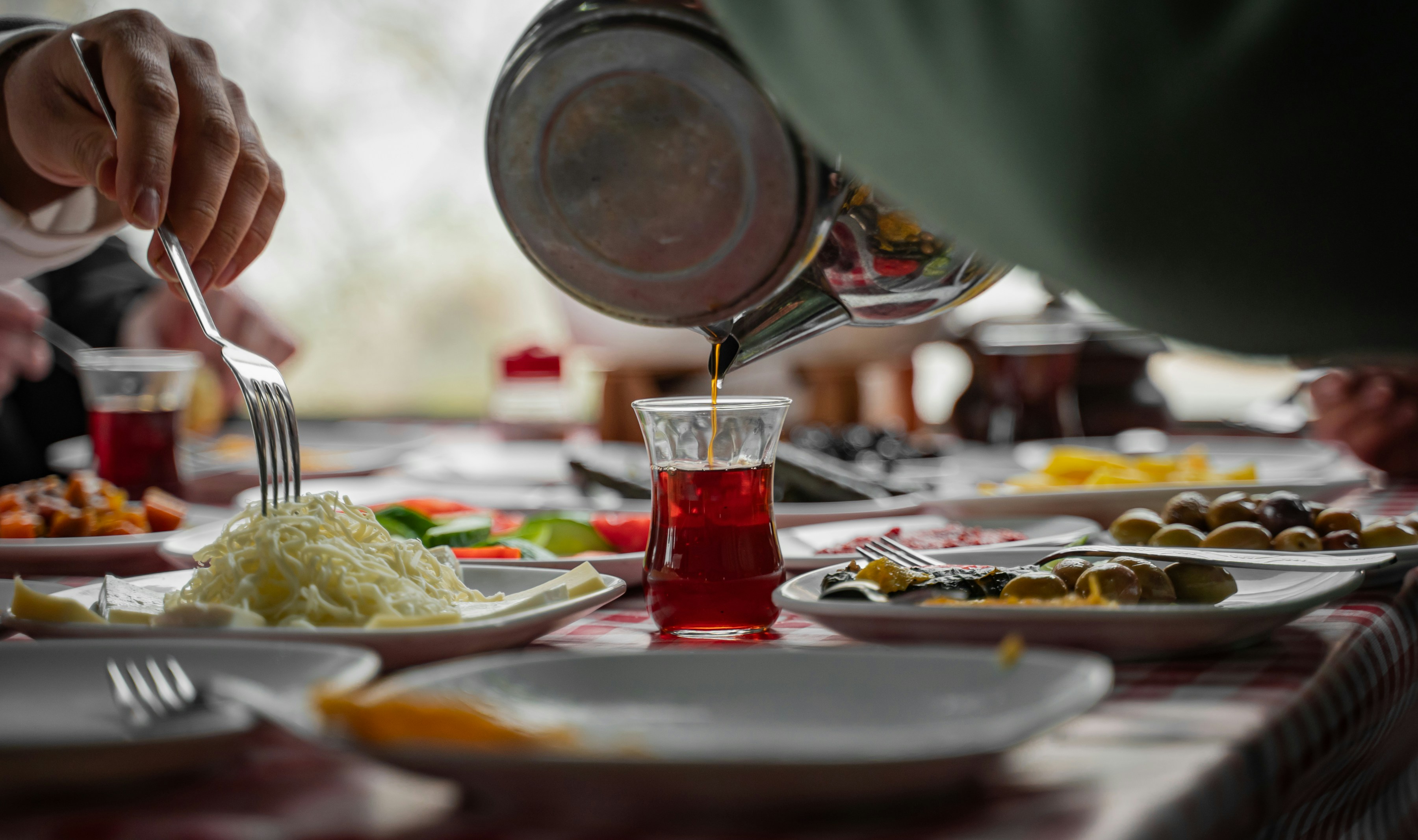Pouring Warmth: Tea Cascades Over a Shared Table