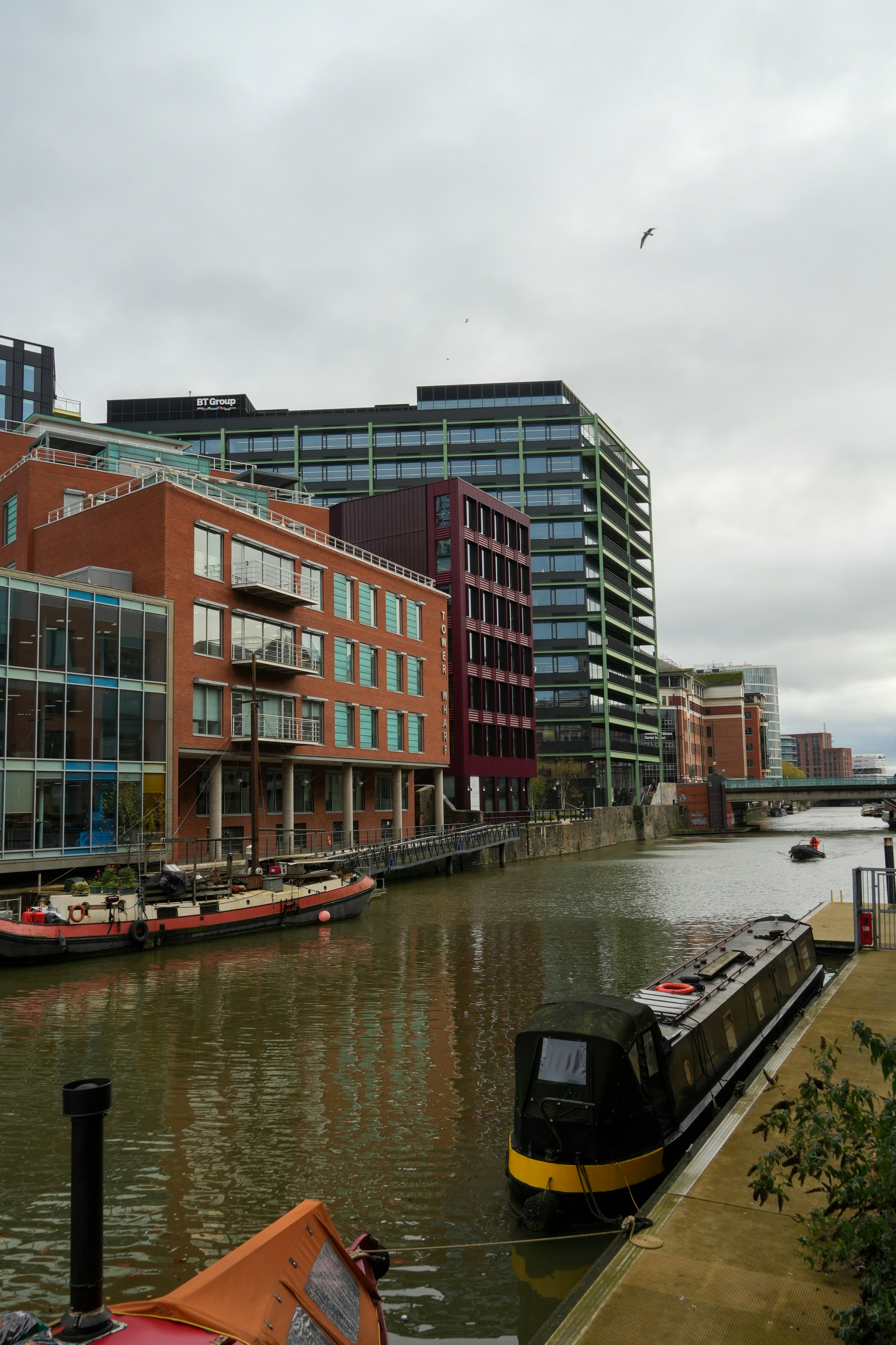 Riverfront Arc: Modern brick and glass buildings along a sunlit canal