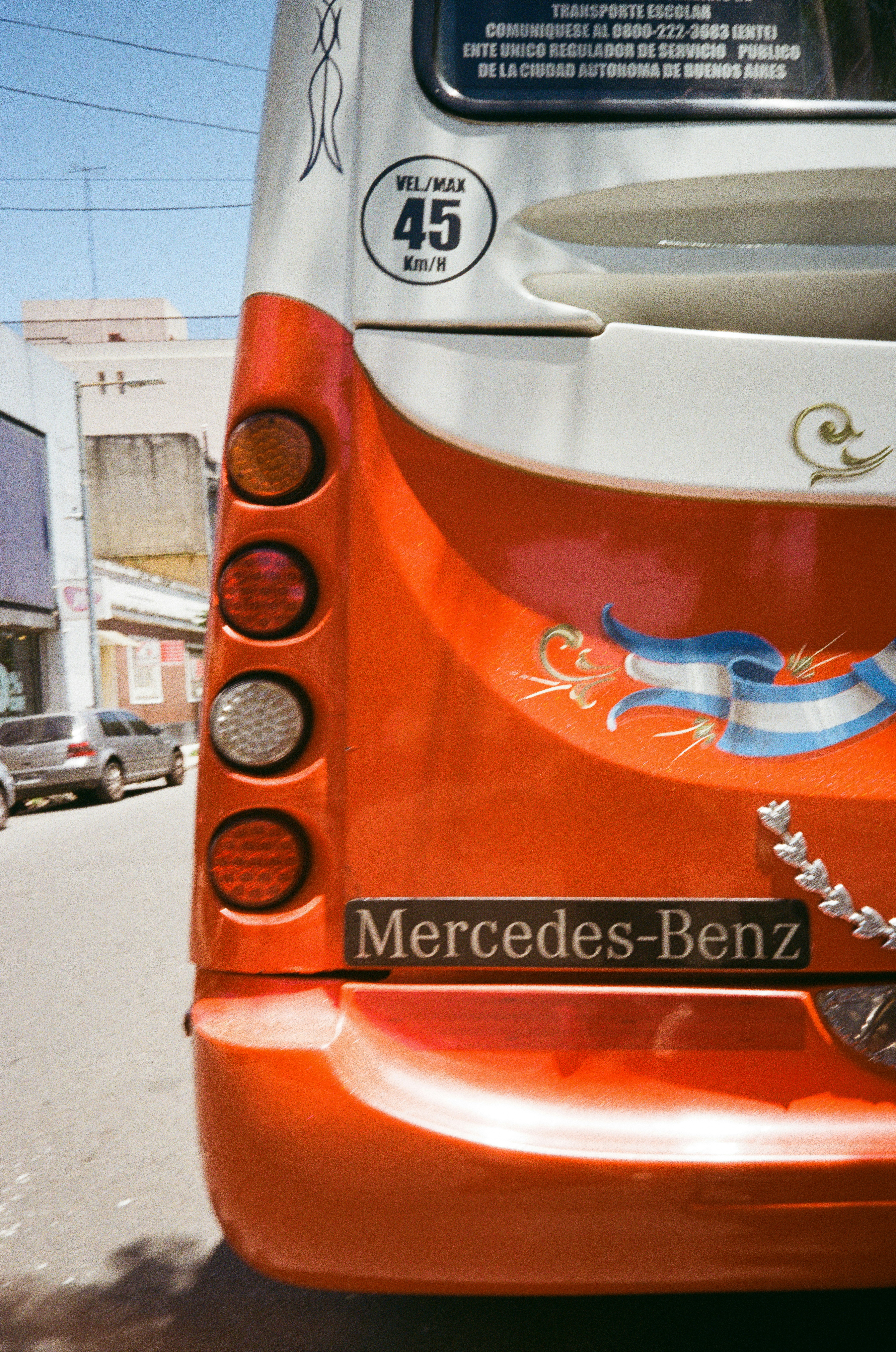 Close-up detail of the rear of a red city bus, highlighting textures, signage, and urban transportation design.